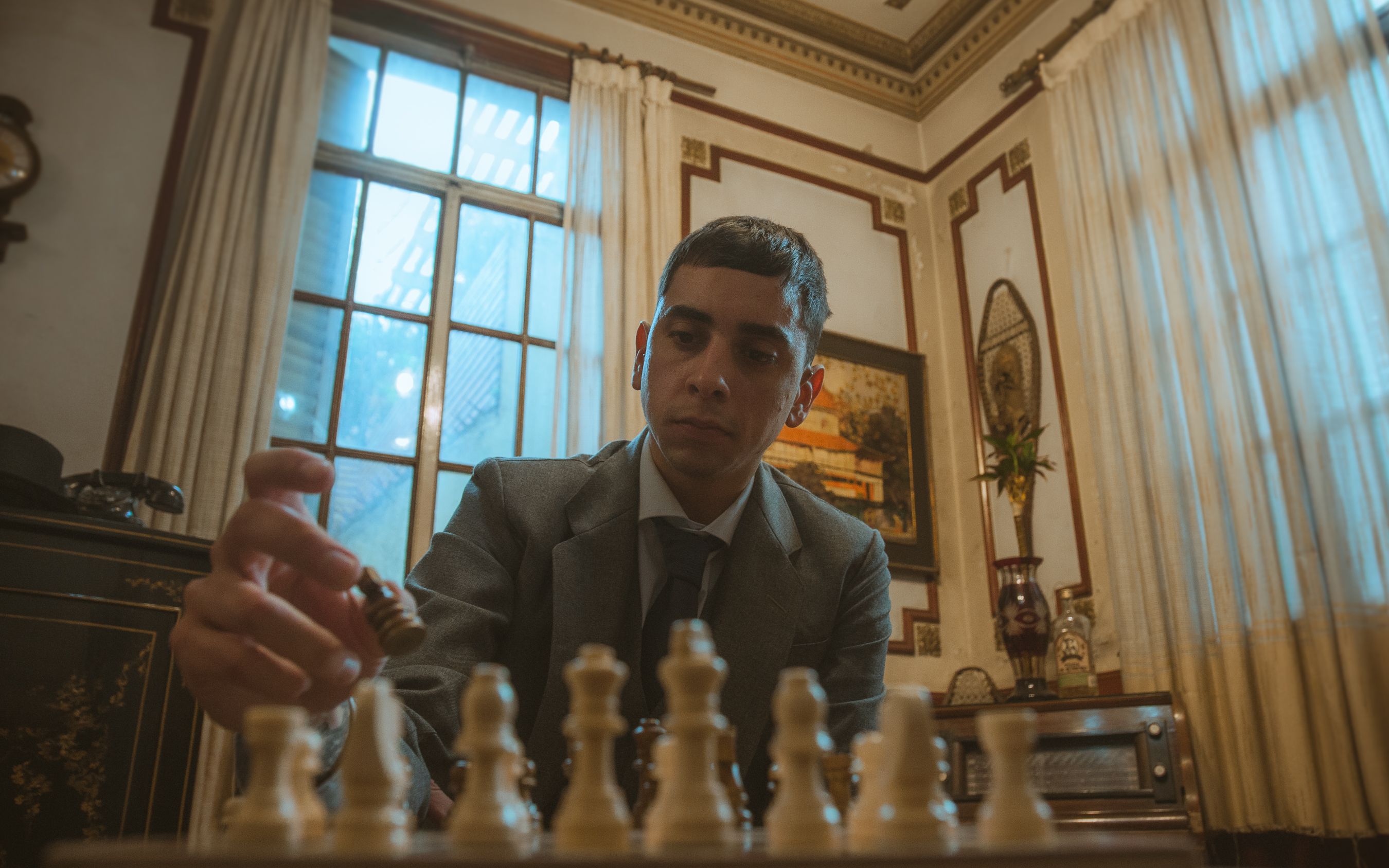 A man in a suit playing chess in a room · Free Stock Photo