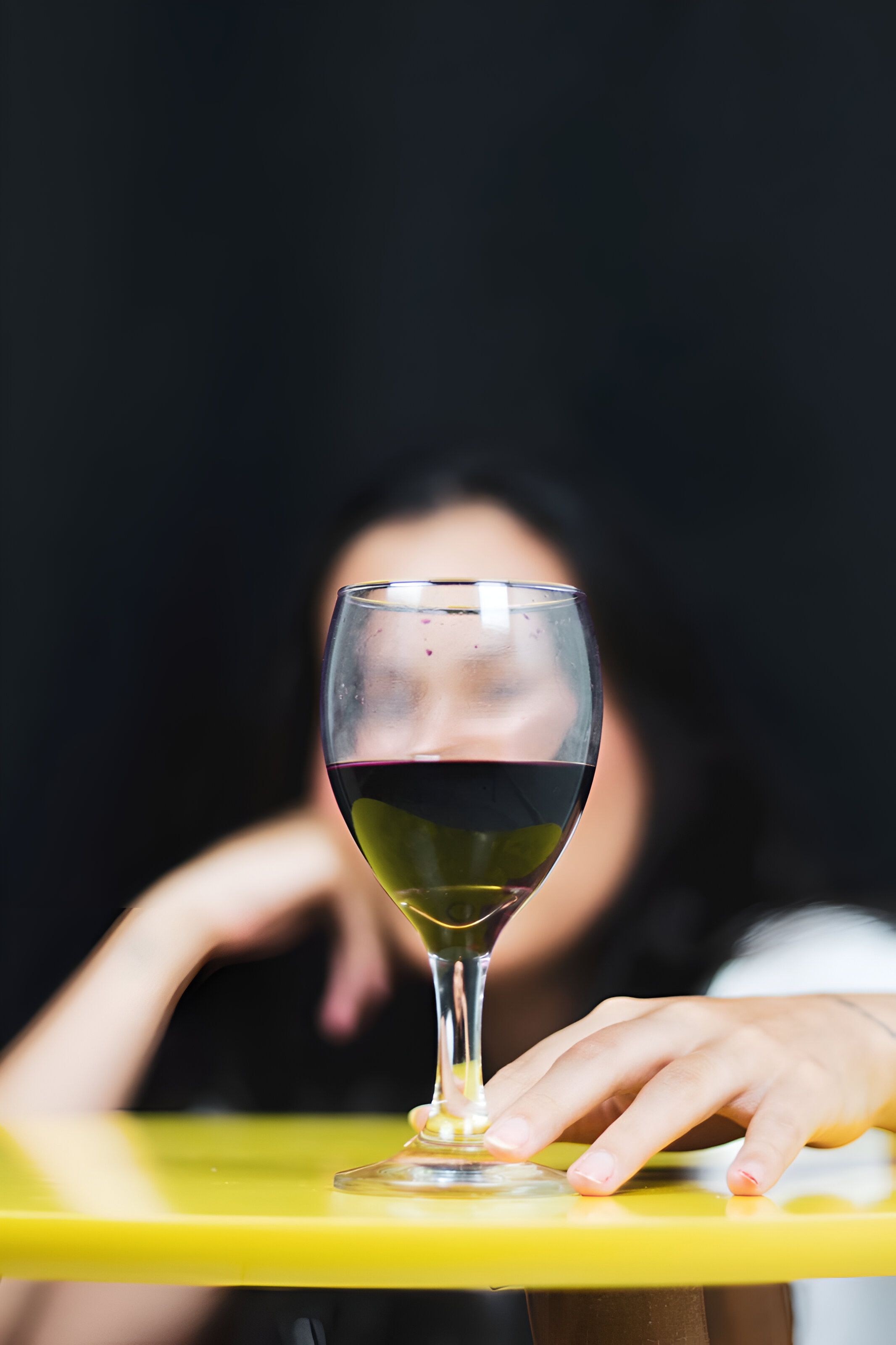 A woman sitting at a table with a glass of wine · Free Stock Photo