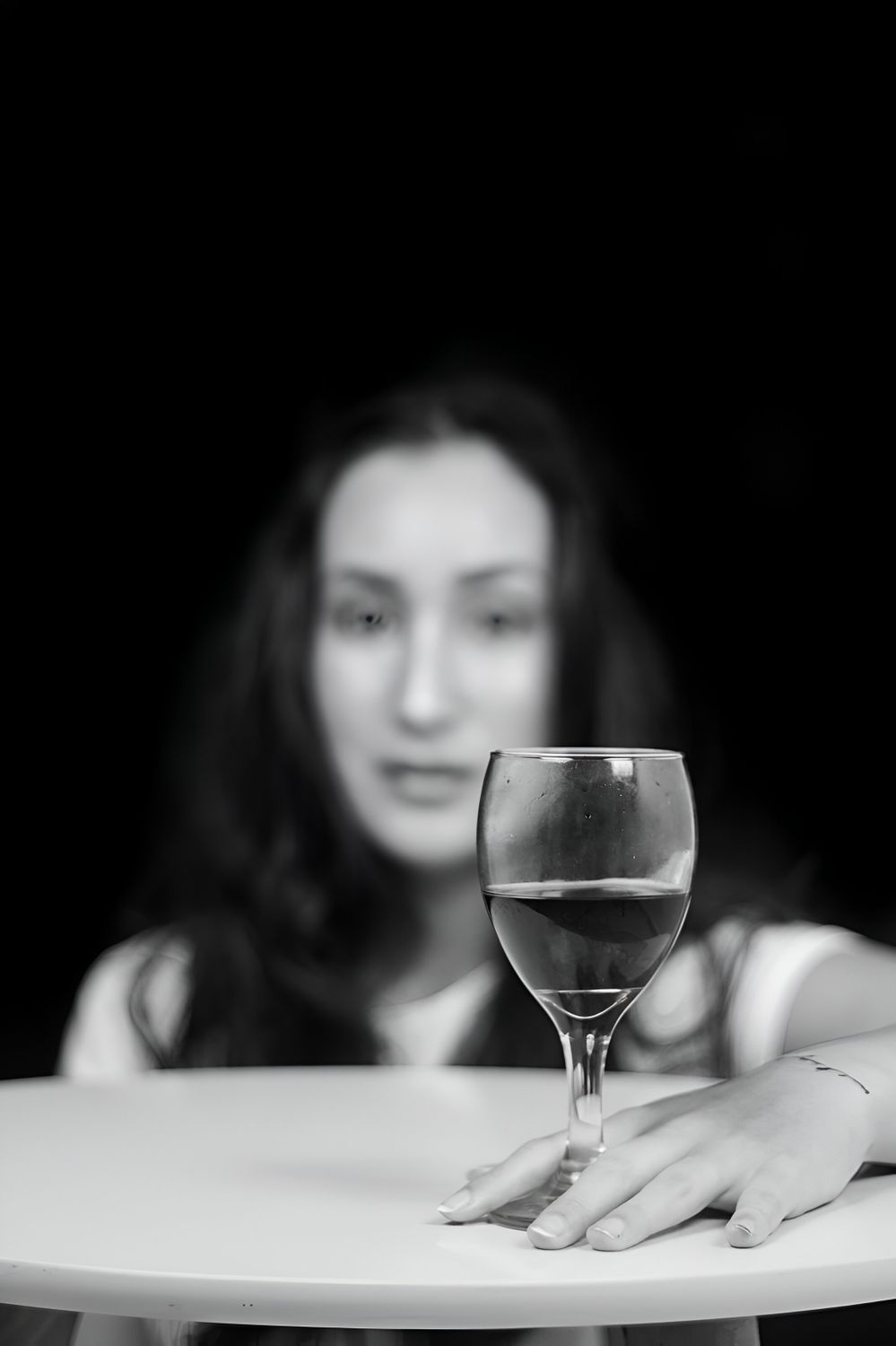 A woman sitting at a table with a glass of wine · Free Stock Photo