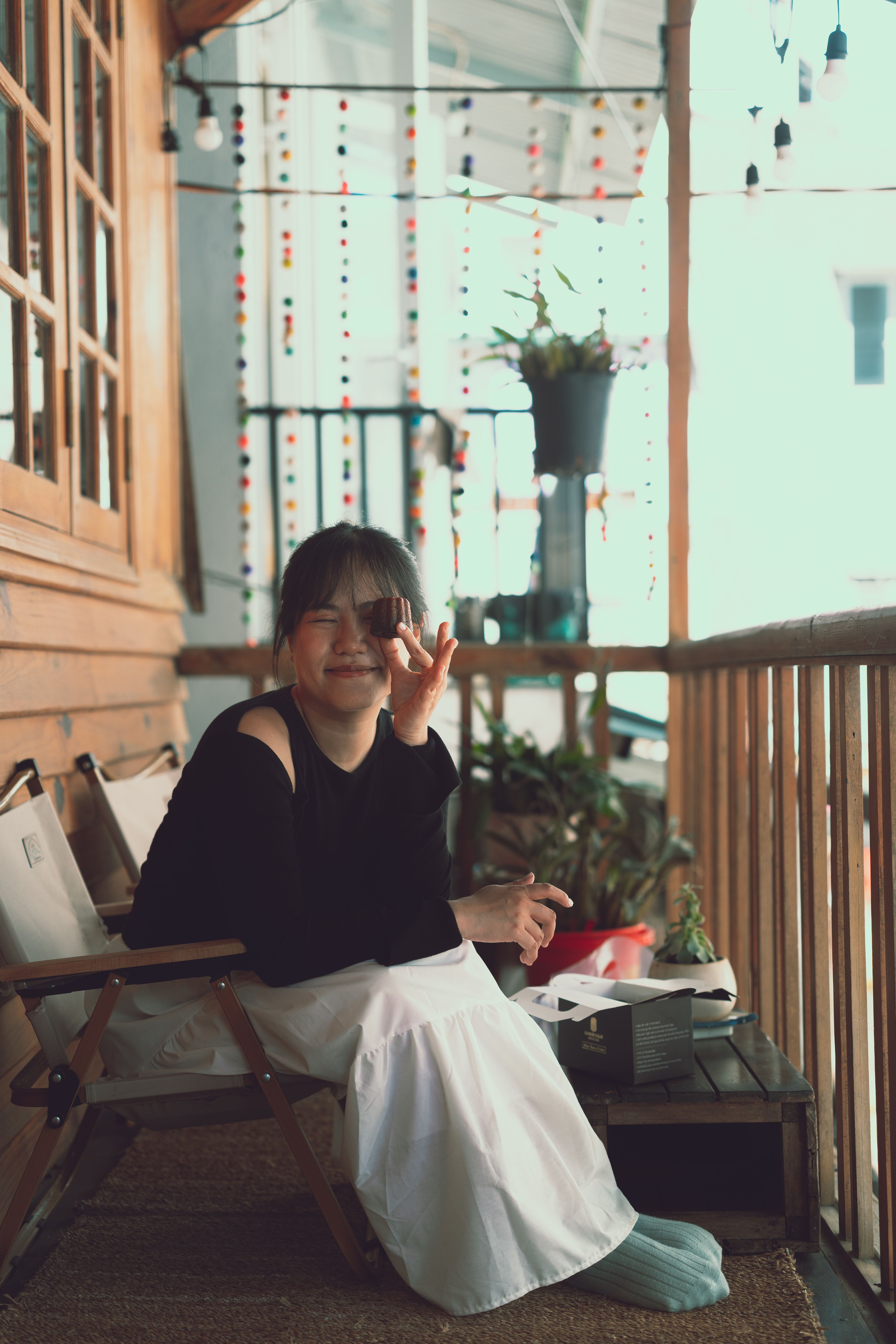 A woman sitting on a porch with a phone · Free Stock Photo