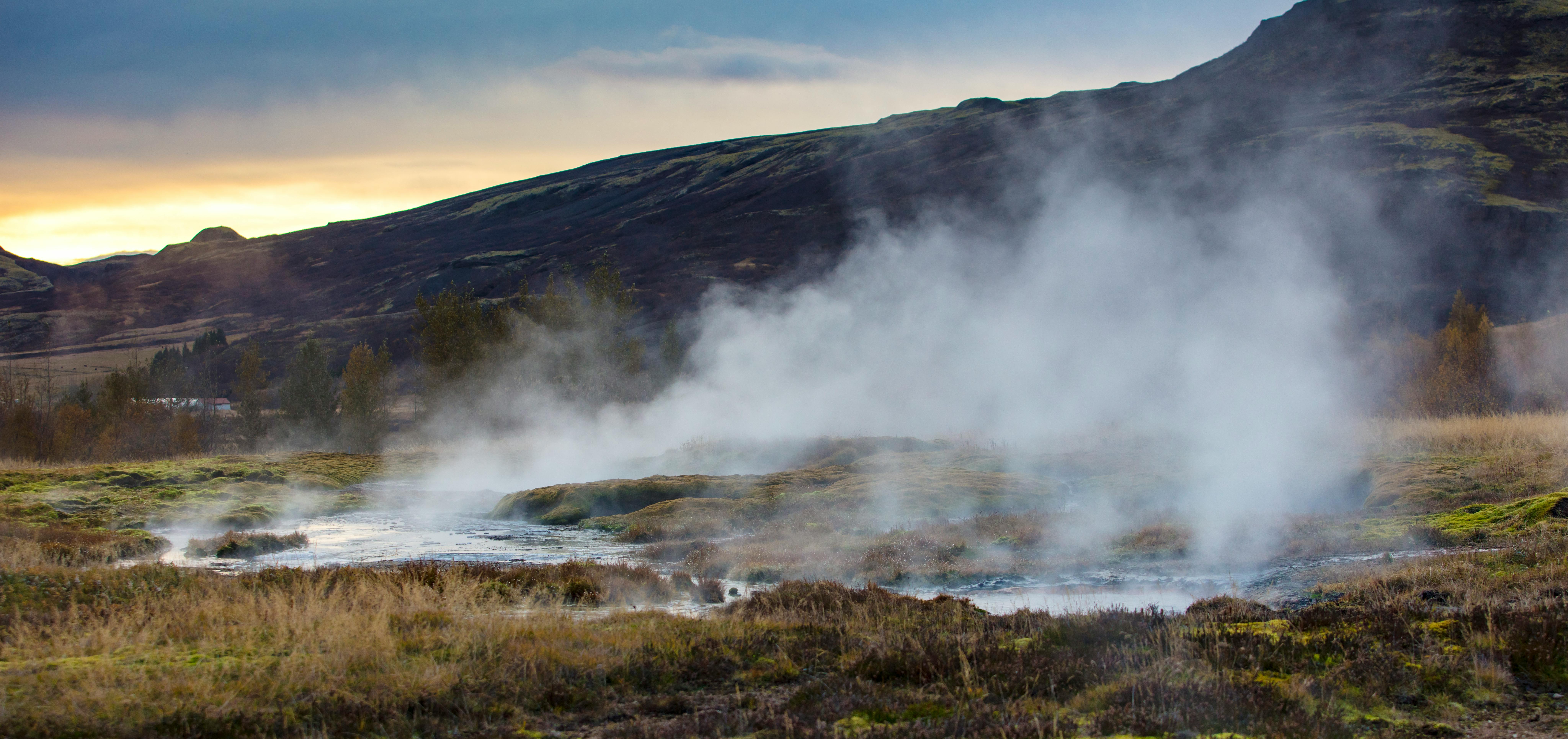 A steamy hot spring in the middle of a field · Free Stock Photo