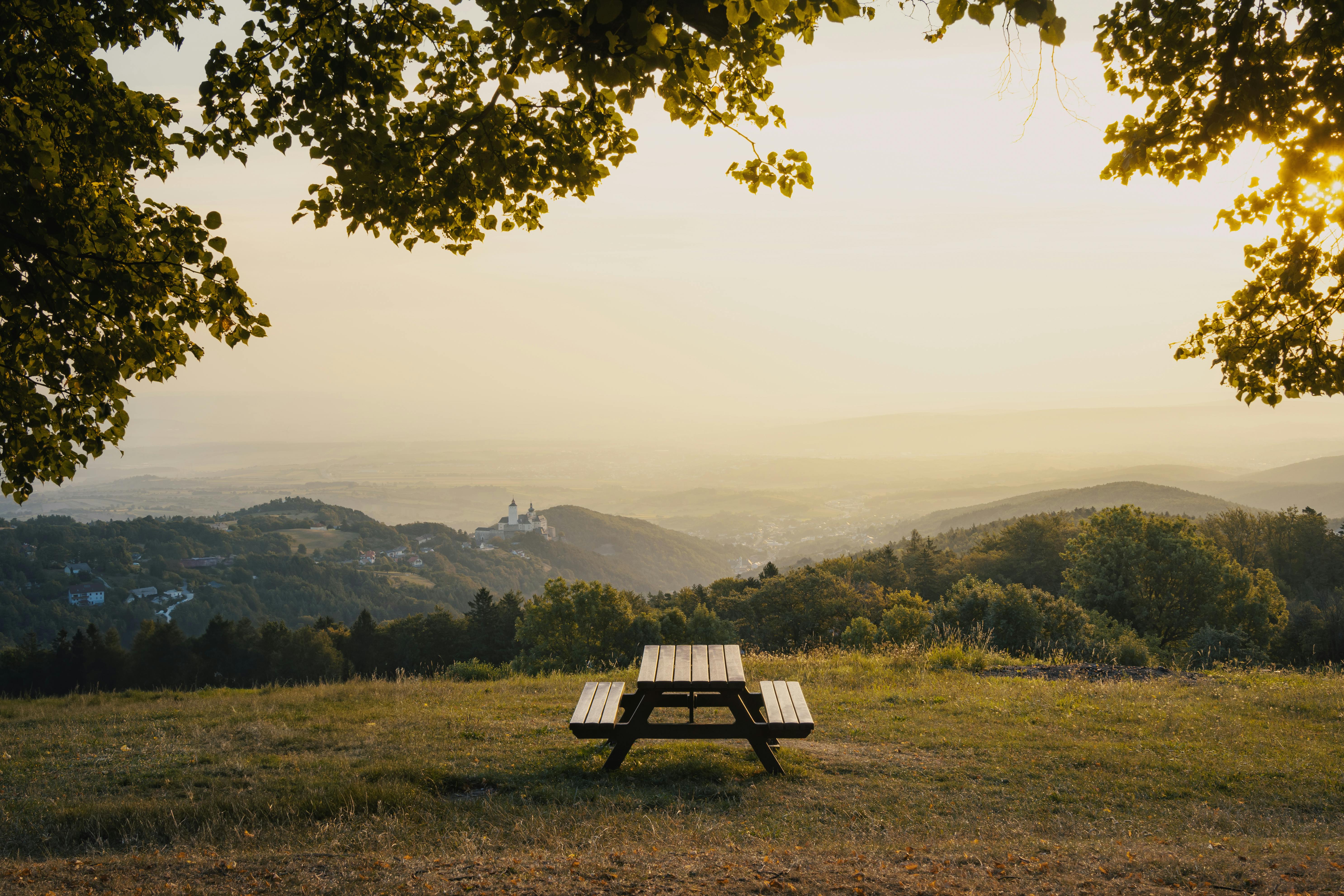 A picnic table on a hillside overlooking a valley · Free Stock Photo