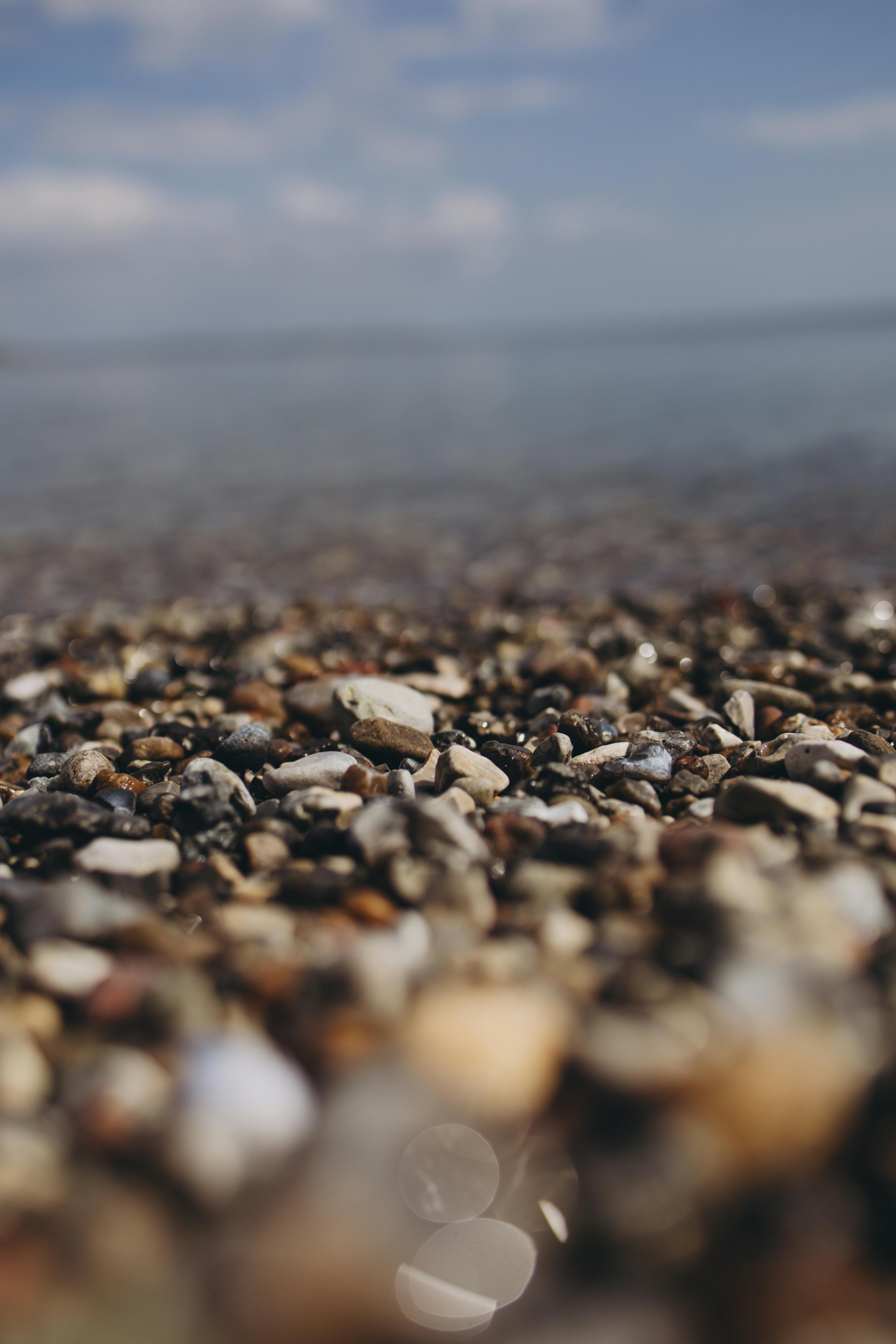 A beach with pebbles and water · Free Stock Photo