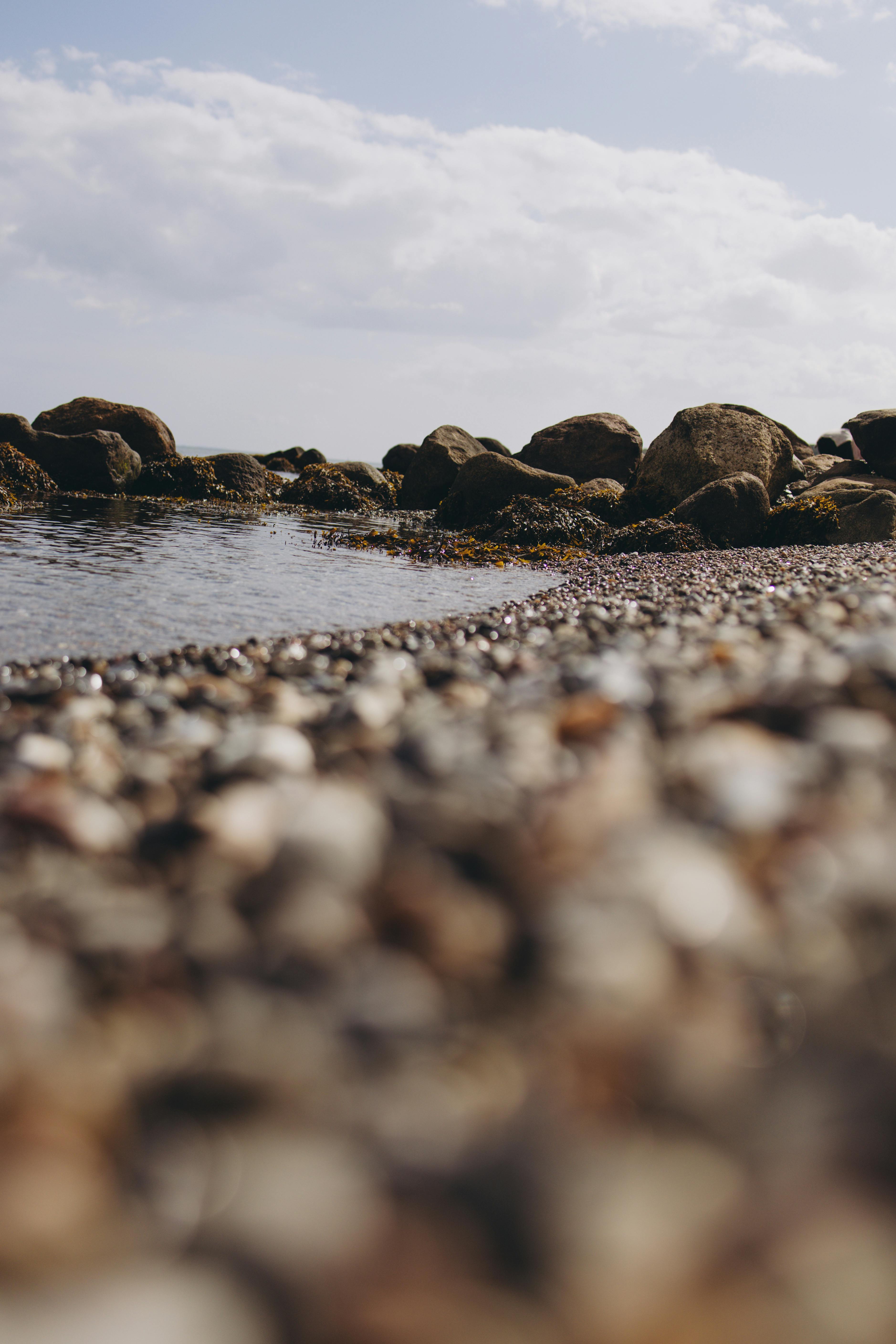 A beach with rocks and pebbles on the shore · Free Stock Photo