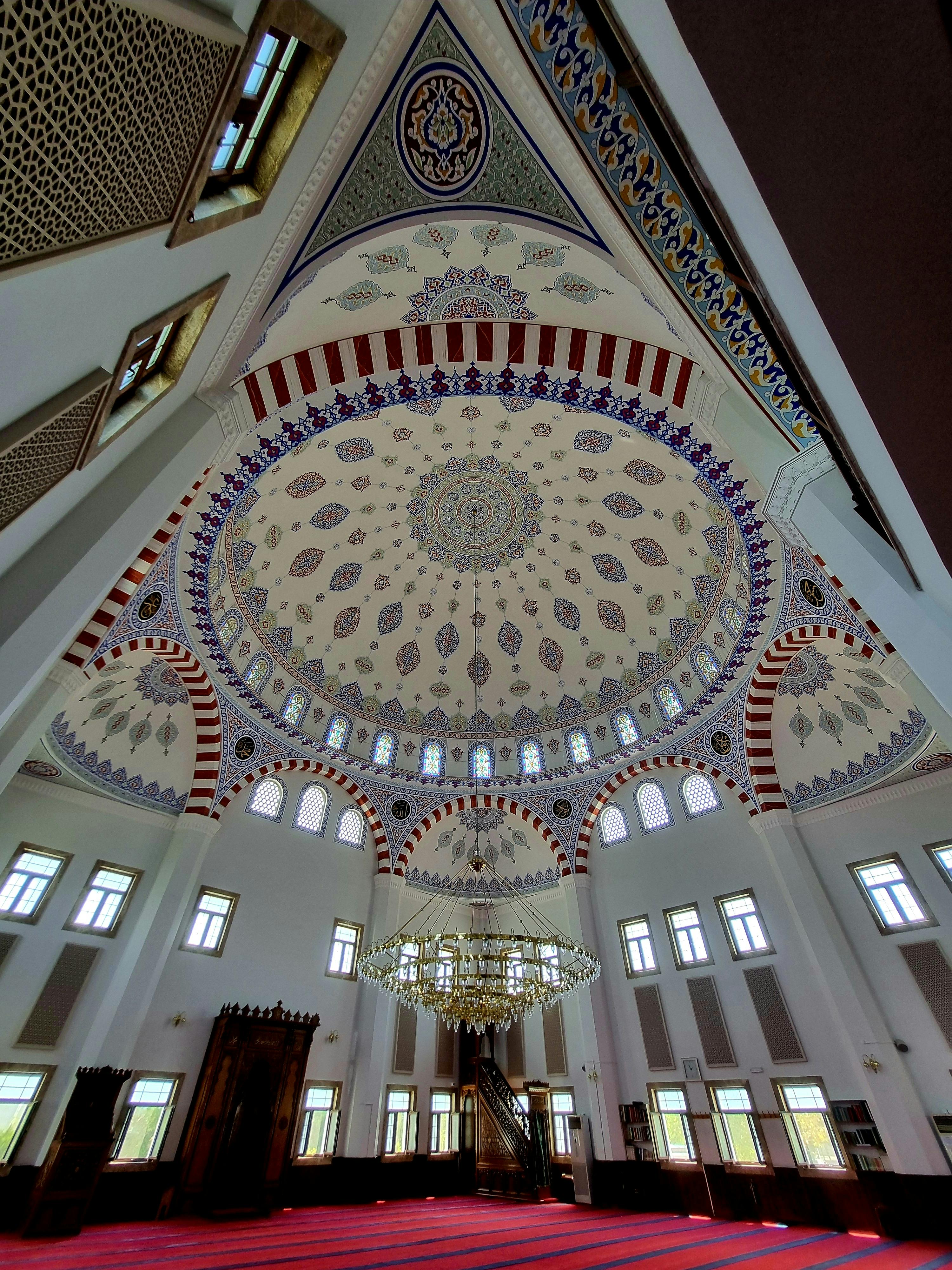 The interior of a mosque with a dome and arches · Free Stock Photo