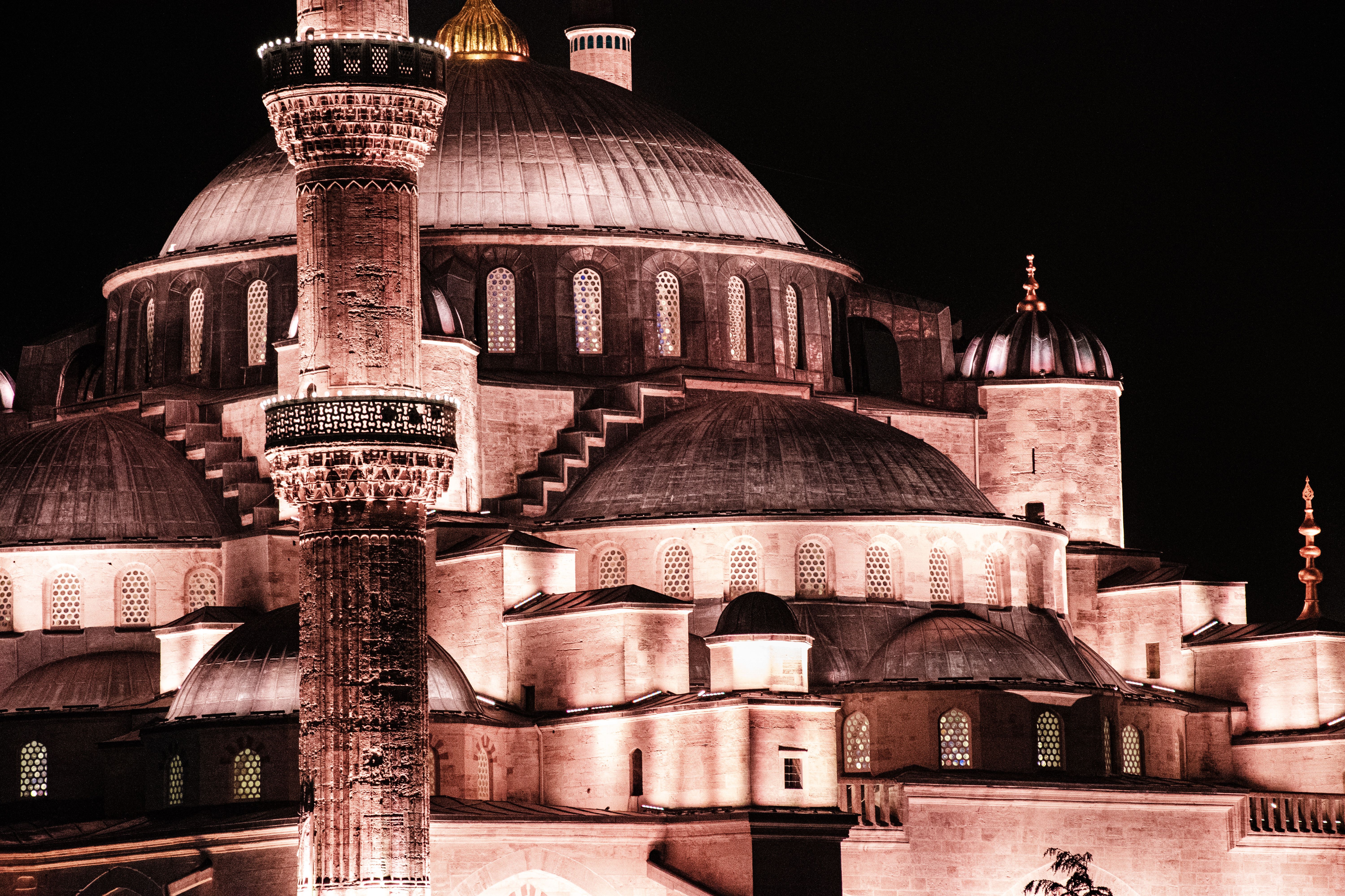 A large mosque with many towers lit up at night · Free Stock Photo