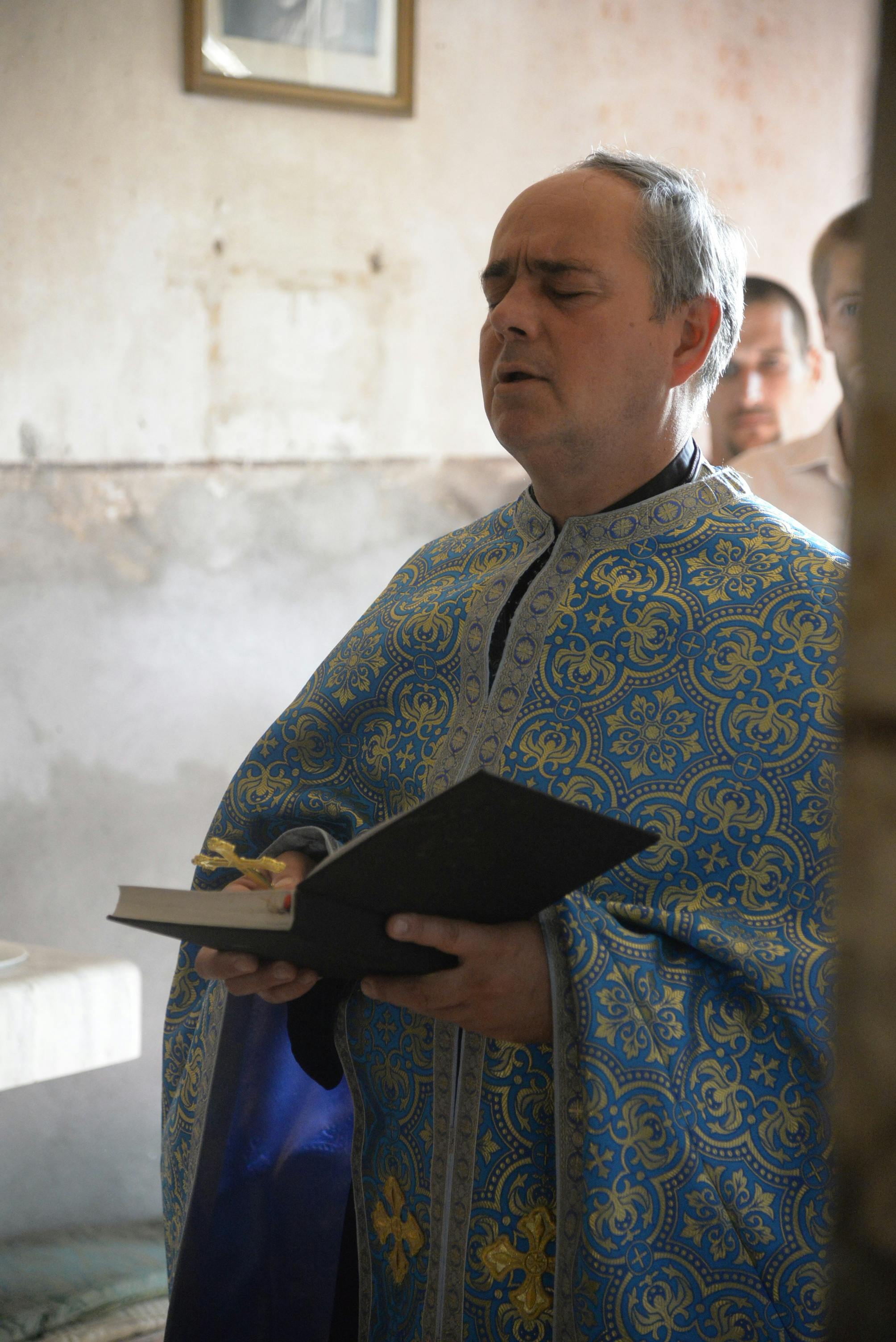A priest in a blue and gold robe holding a book · Free Stock Photo