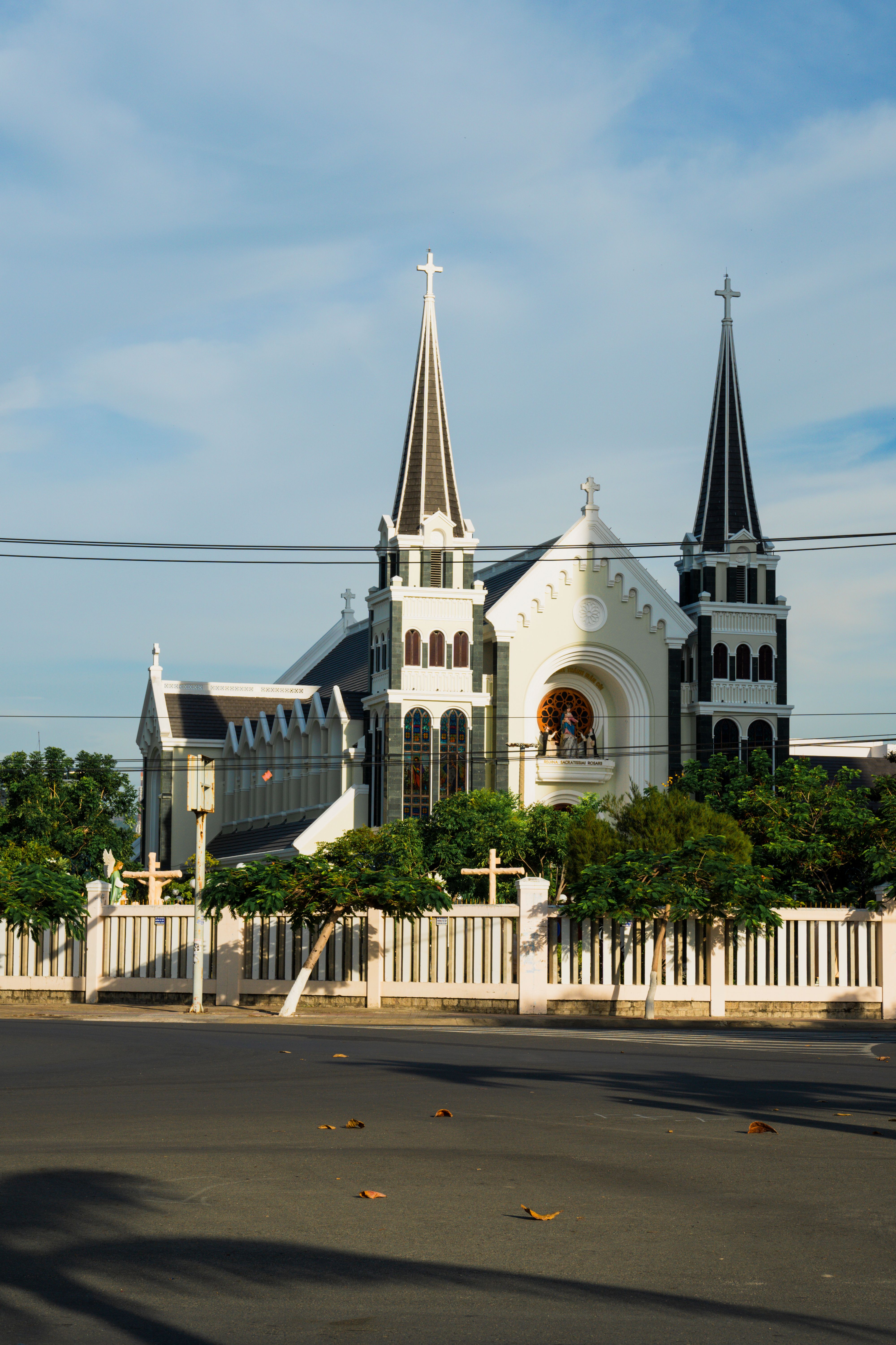 A church with two spires and a white fence · Free Stock Photo