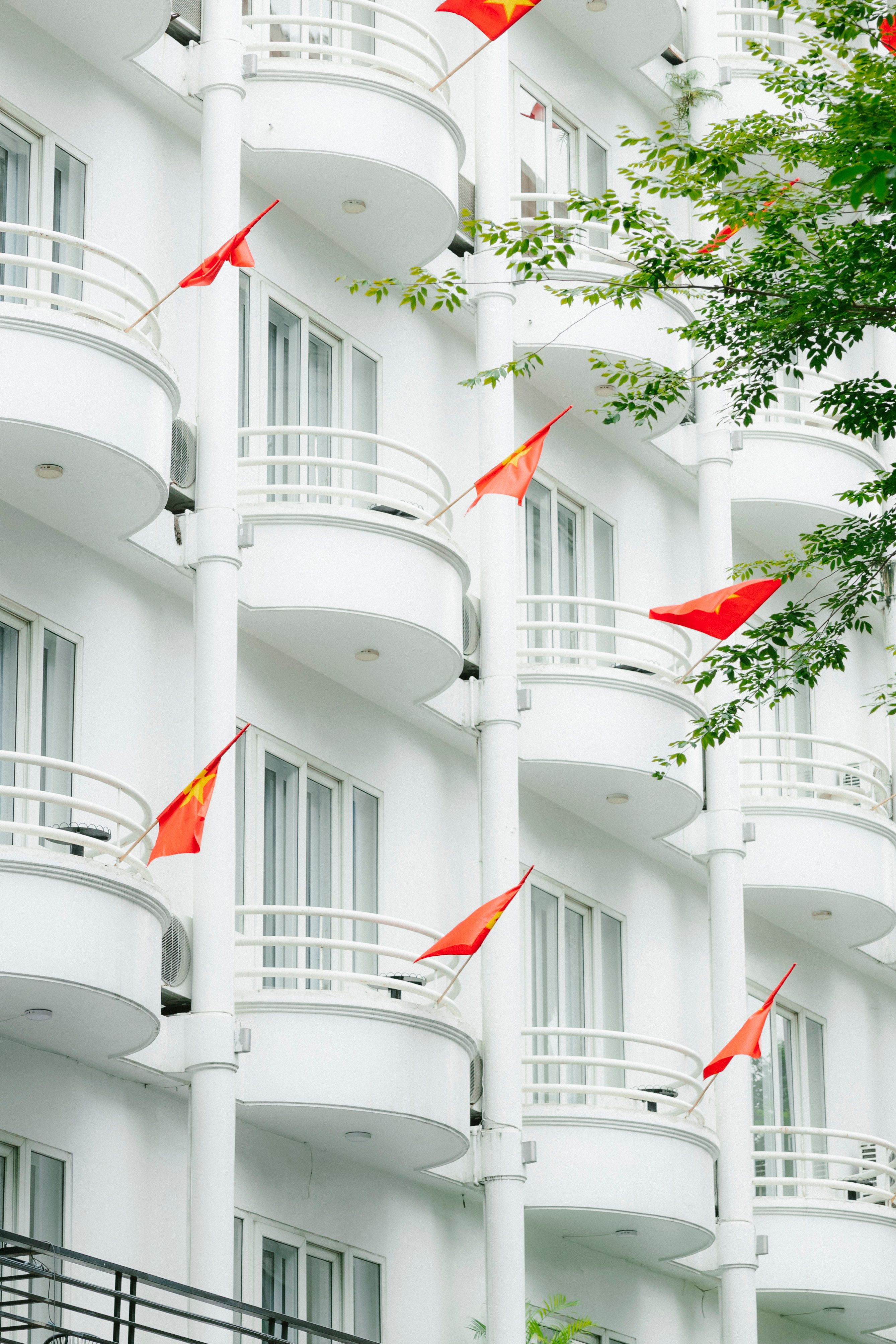 Modern White Apartment Building with Flags · Free Stock Photo