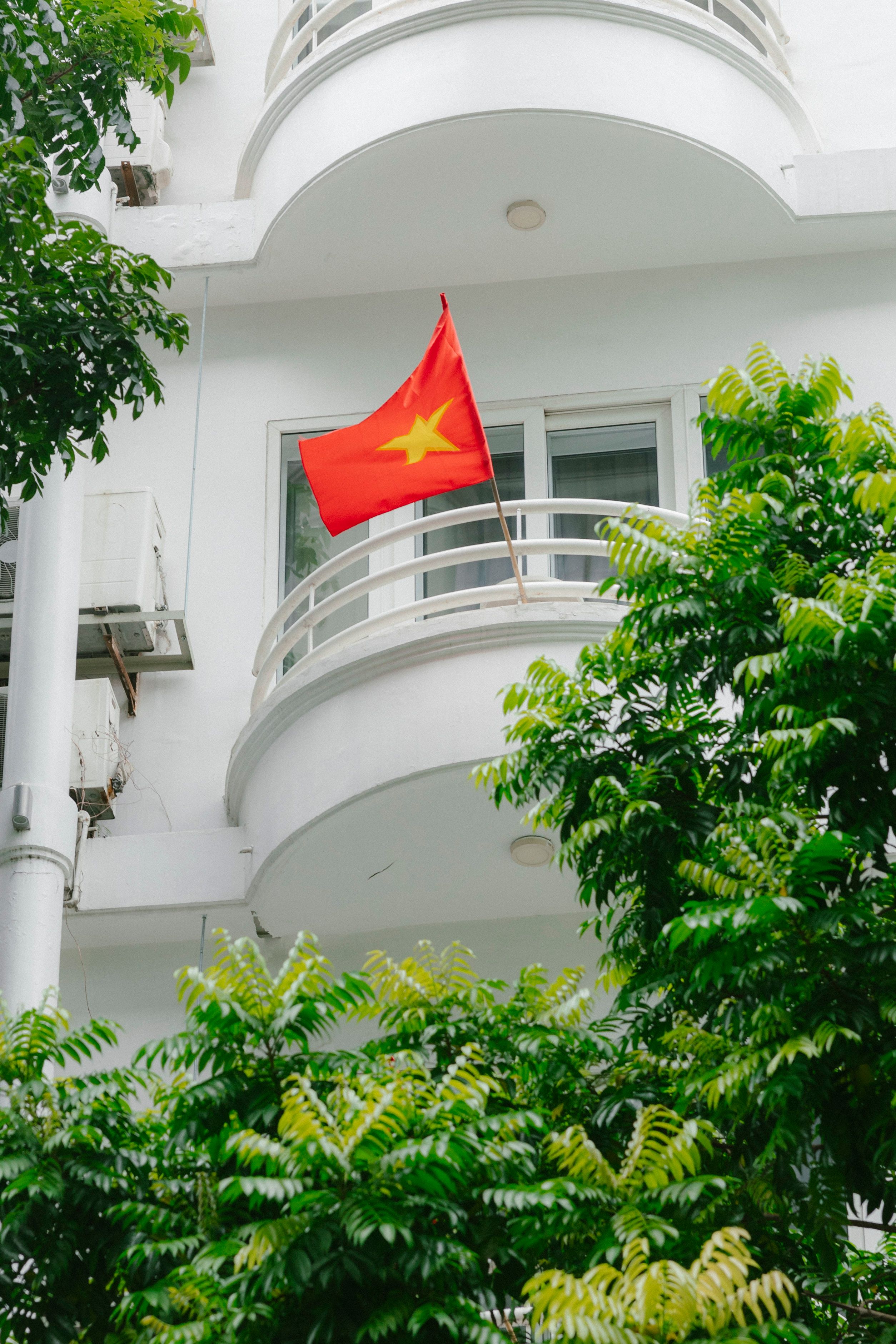 Vietnamese Flag on Urban Balcony with Trees · Free Stock Photo