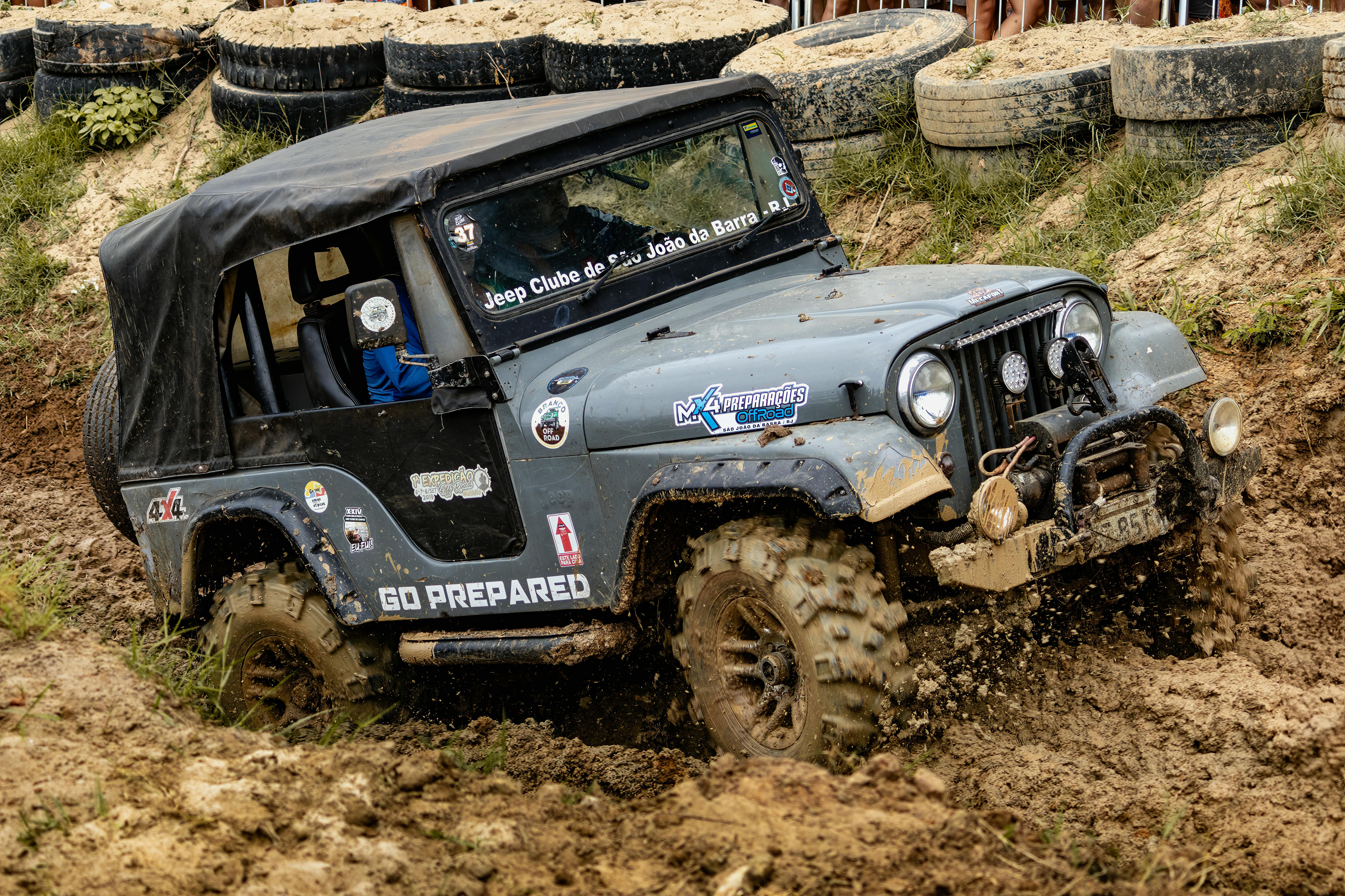 A jeep driving through mud on a dirt road · Free Stock Photo