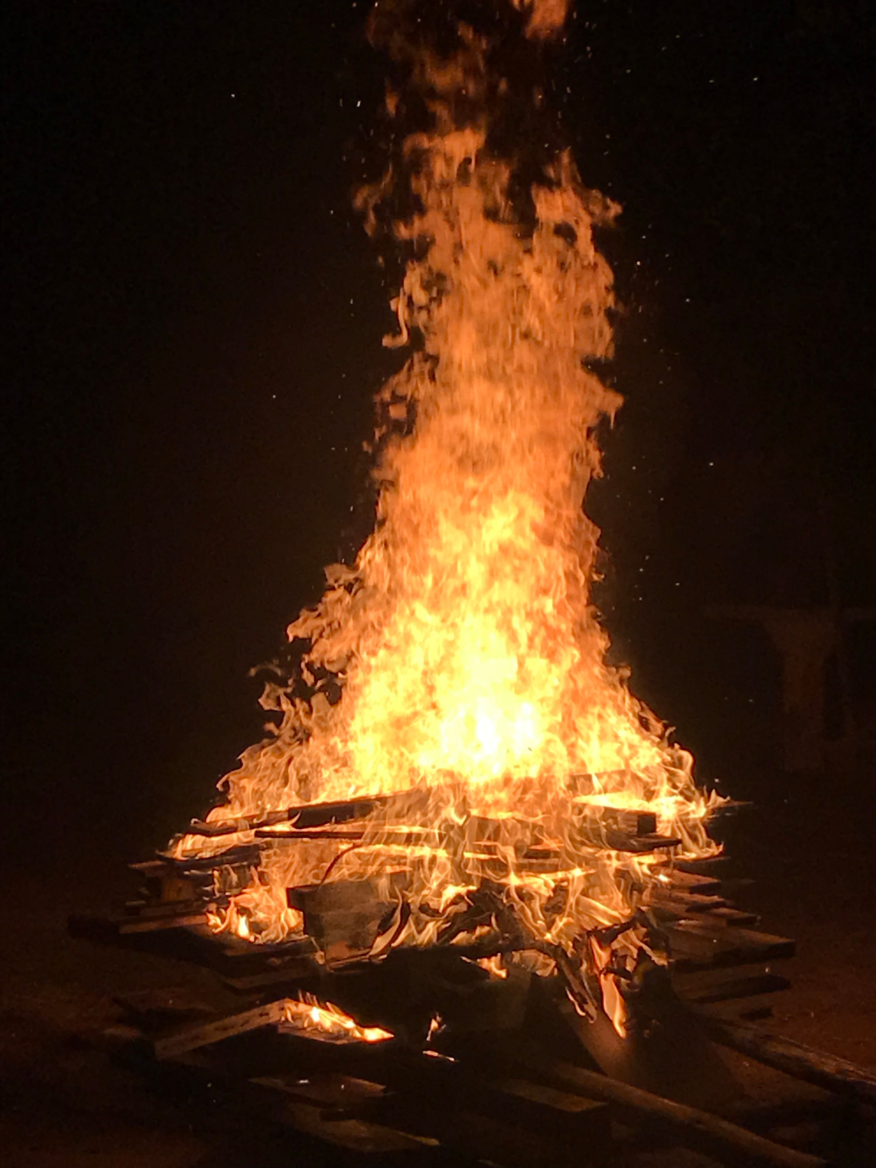 A bonfire is lit up in the dark · Free Stock Photo