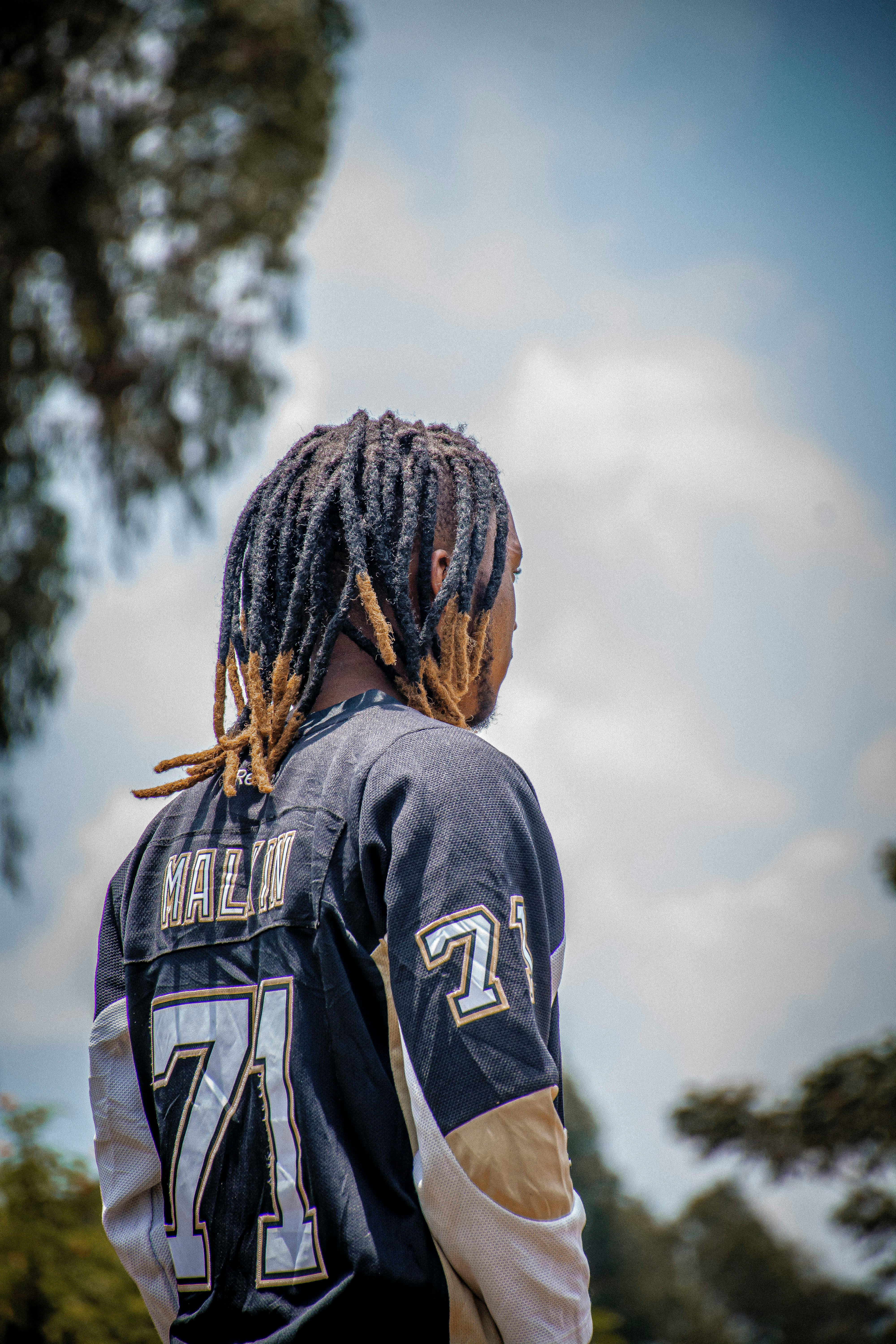 A man with dreadlocks wearing a football jersey · Free Stock Photo