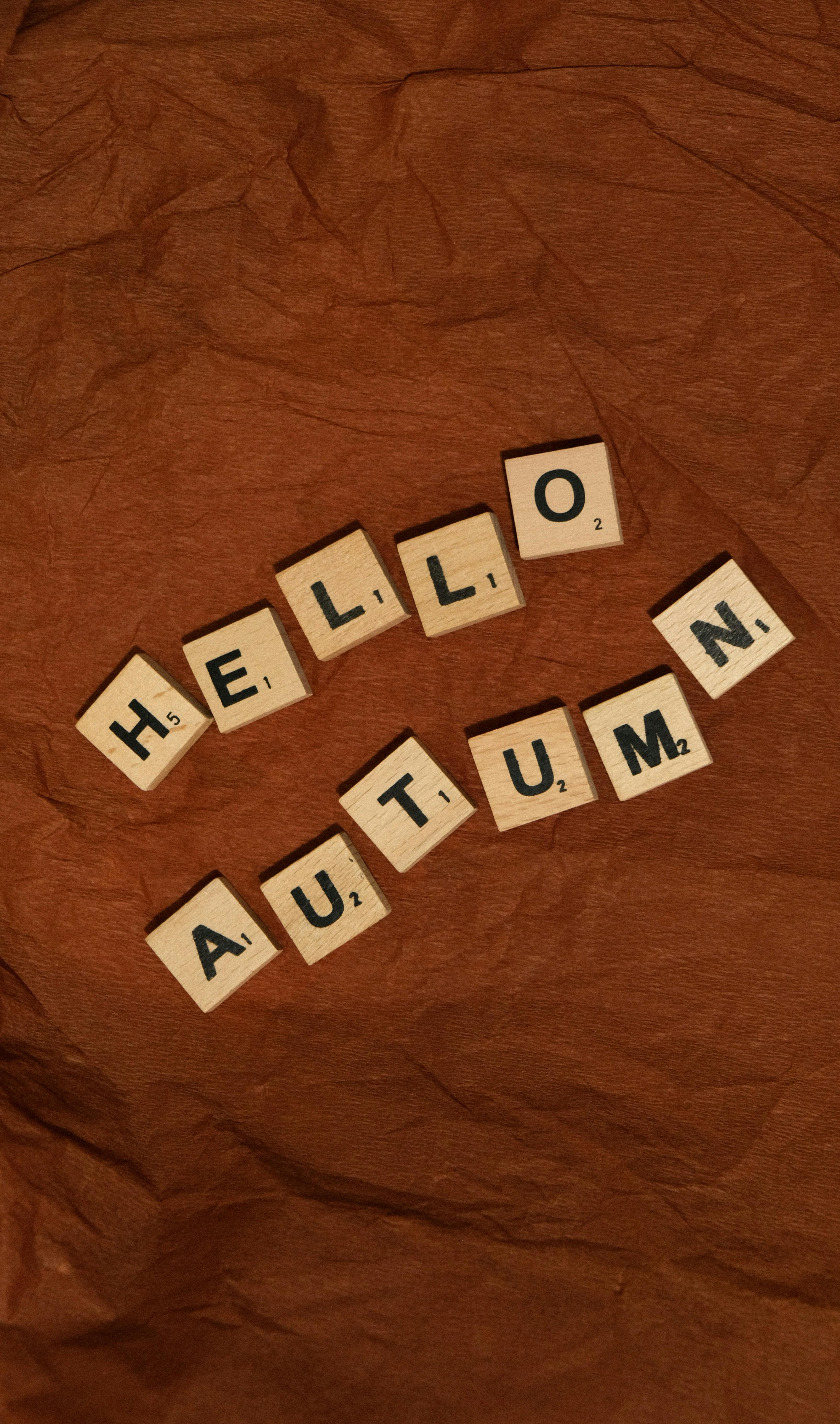 Hello autumn written in scrabble letters on brown paper · Free Stock Photo