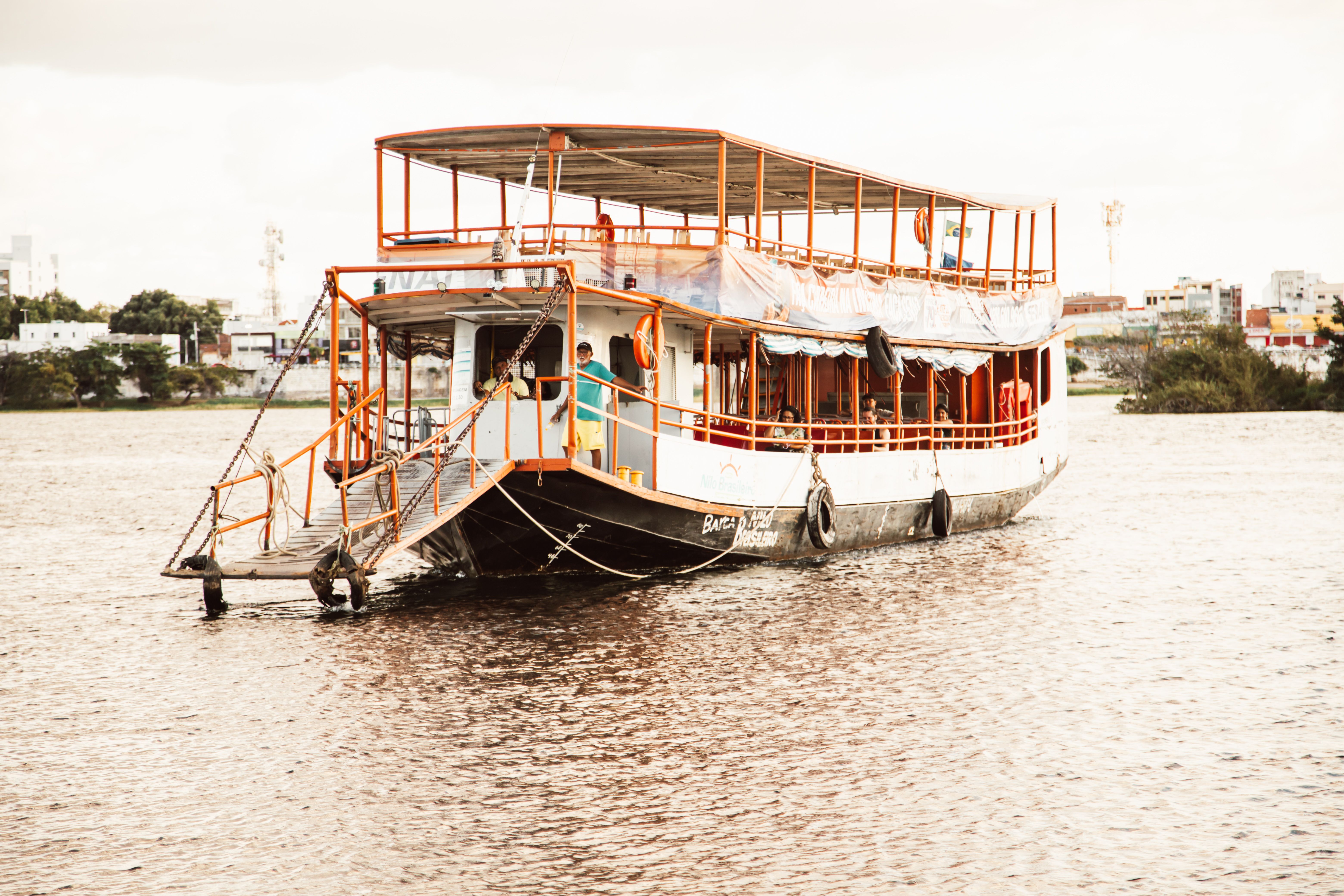 A boat is traveling down a river with people on it · Free Stock Photo