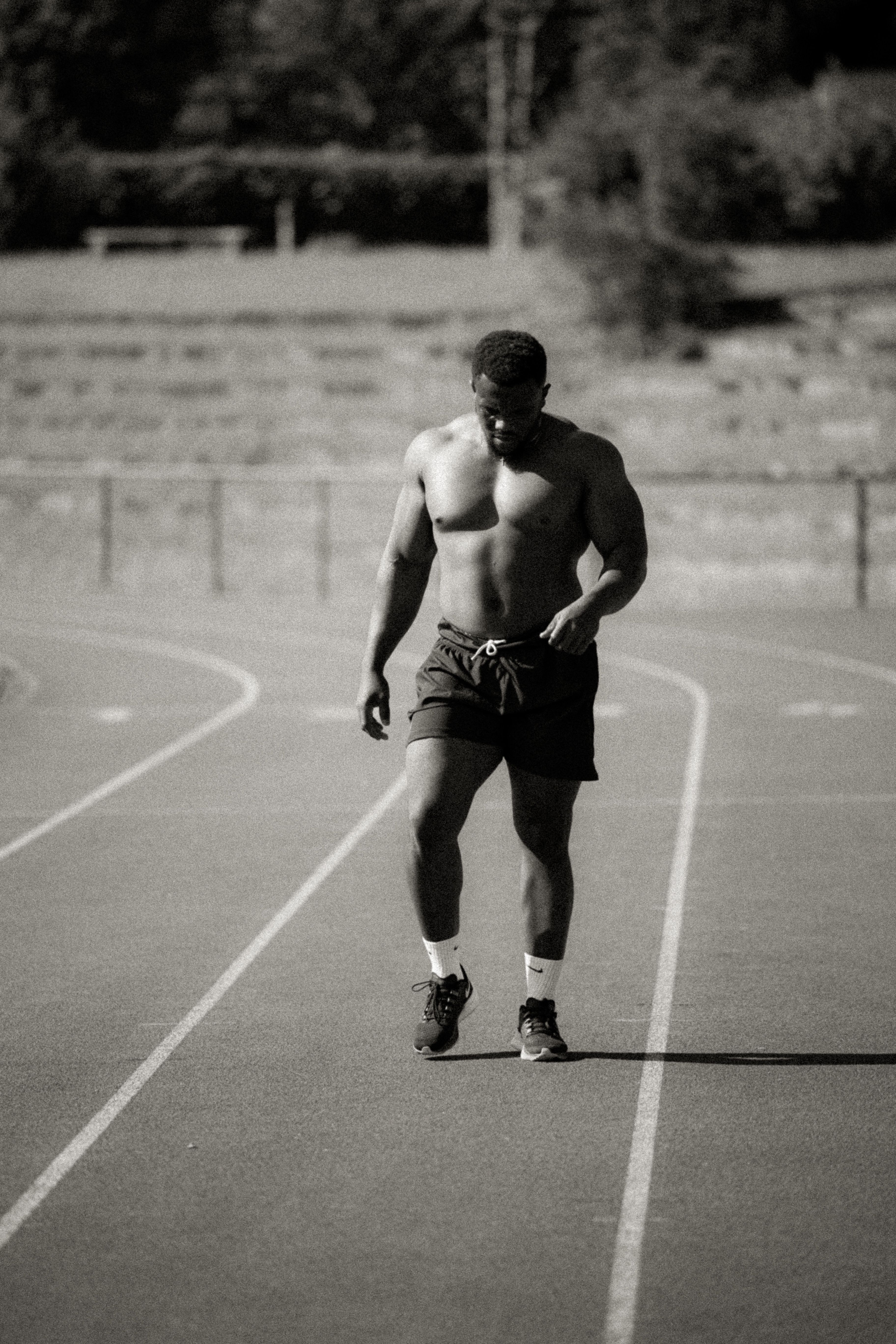 A black and white photo of a man running on a track · Free Stock Photo