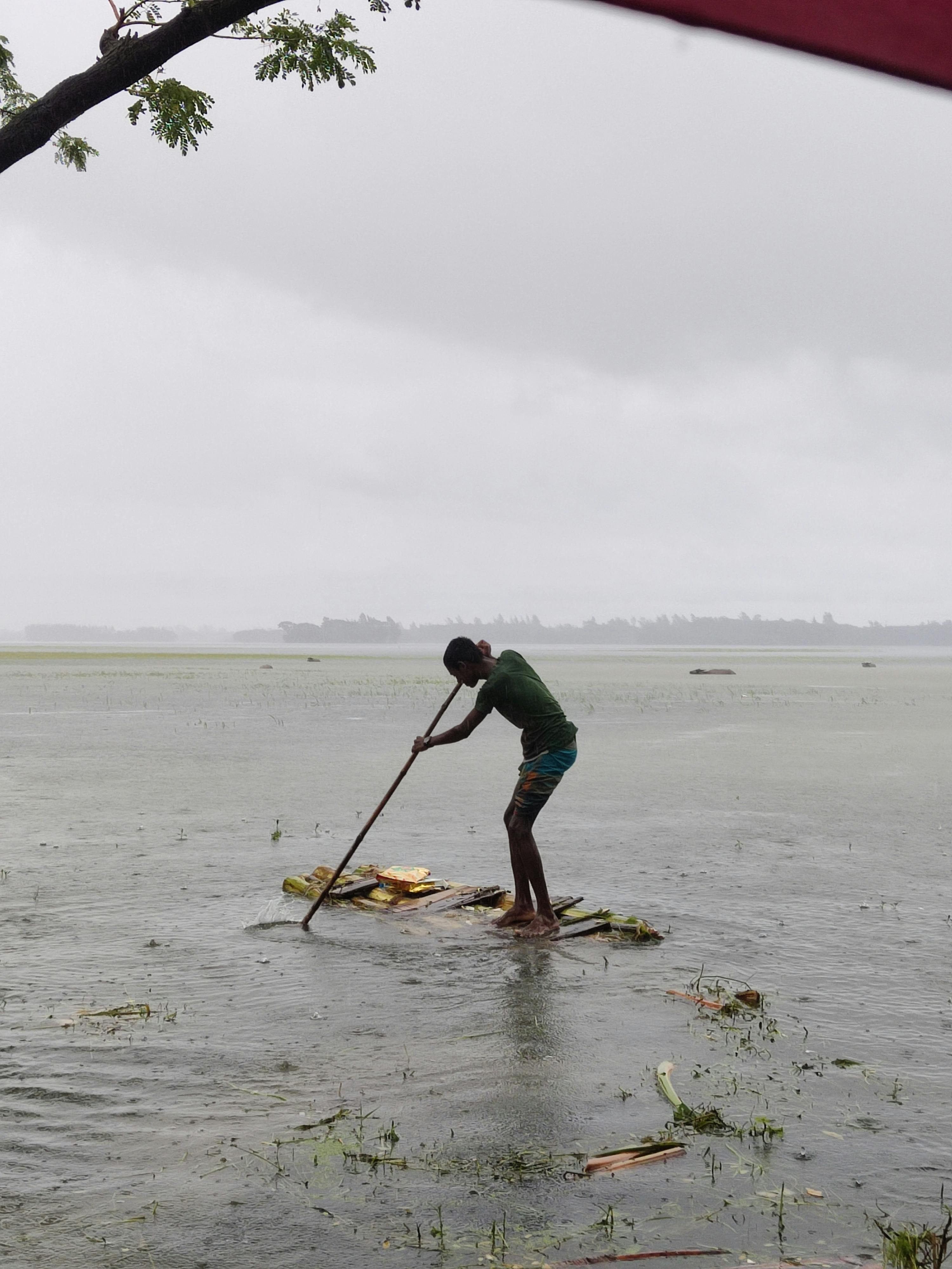 Man Sailing on Raft in Flooded Landscape · Free Stock Photo