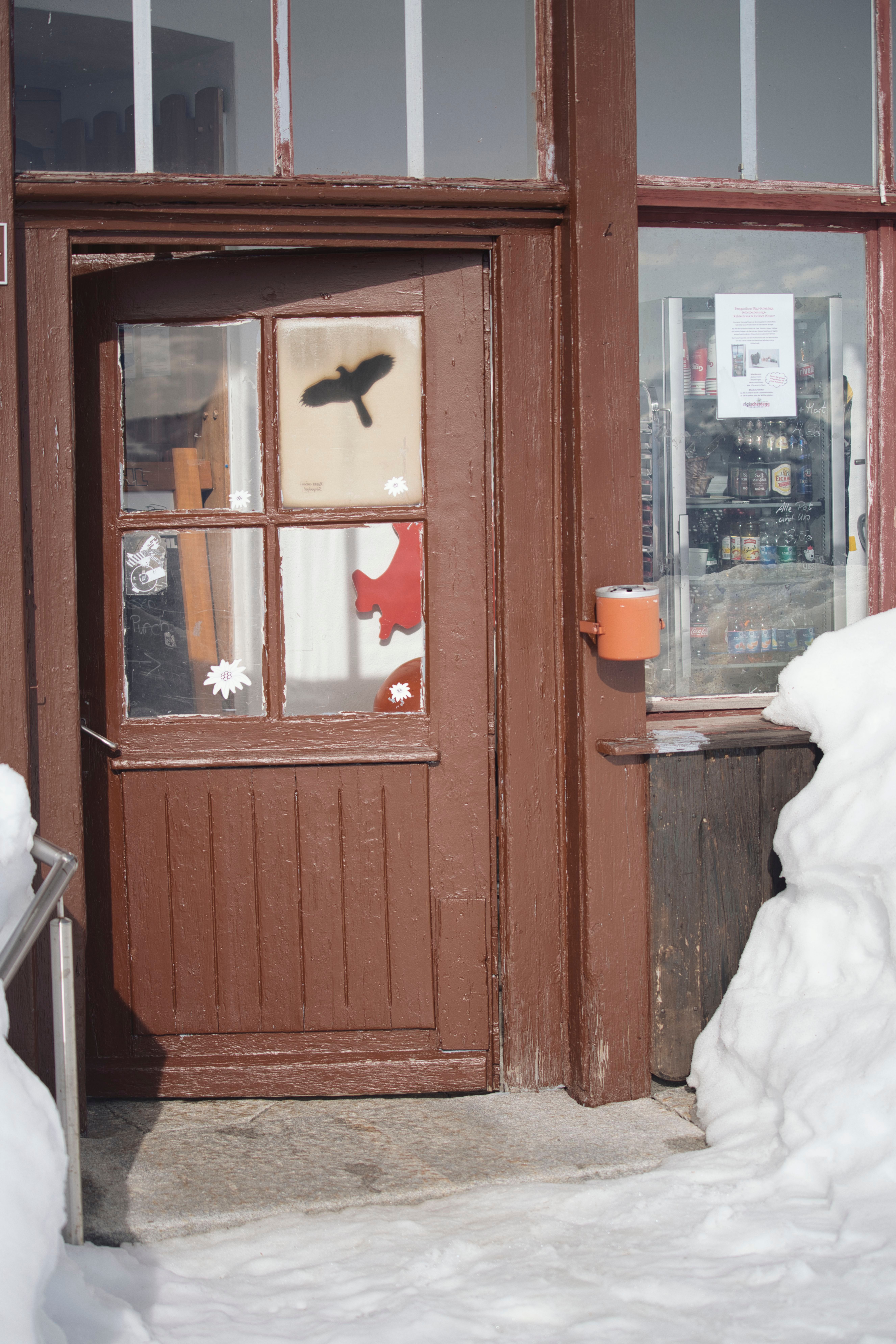 A door to a building with snow on the ground · Free Stock Photo