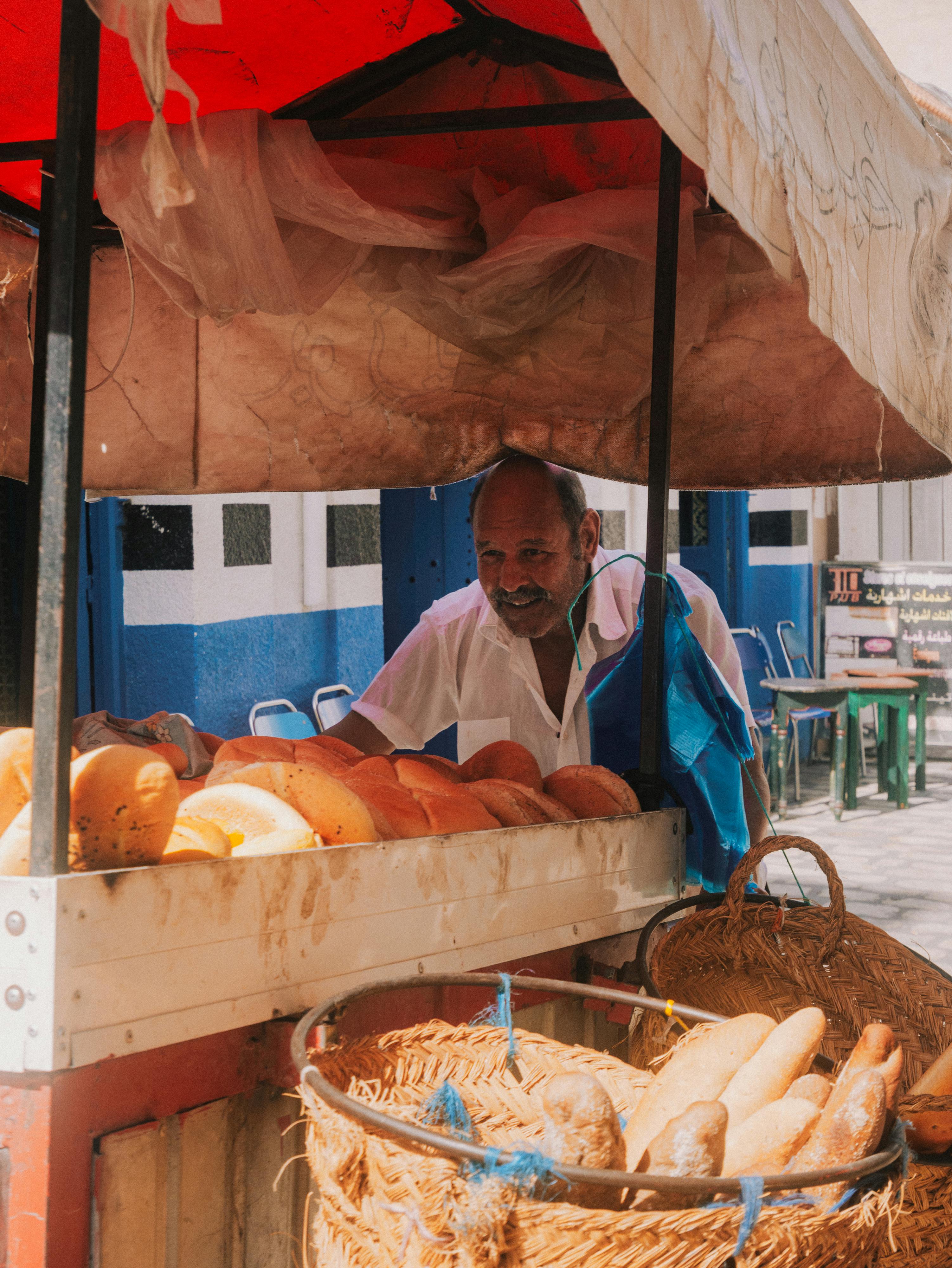 A man selling bread at a market · Free Stock Photo