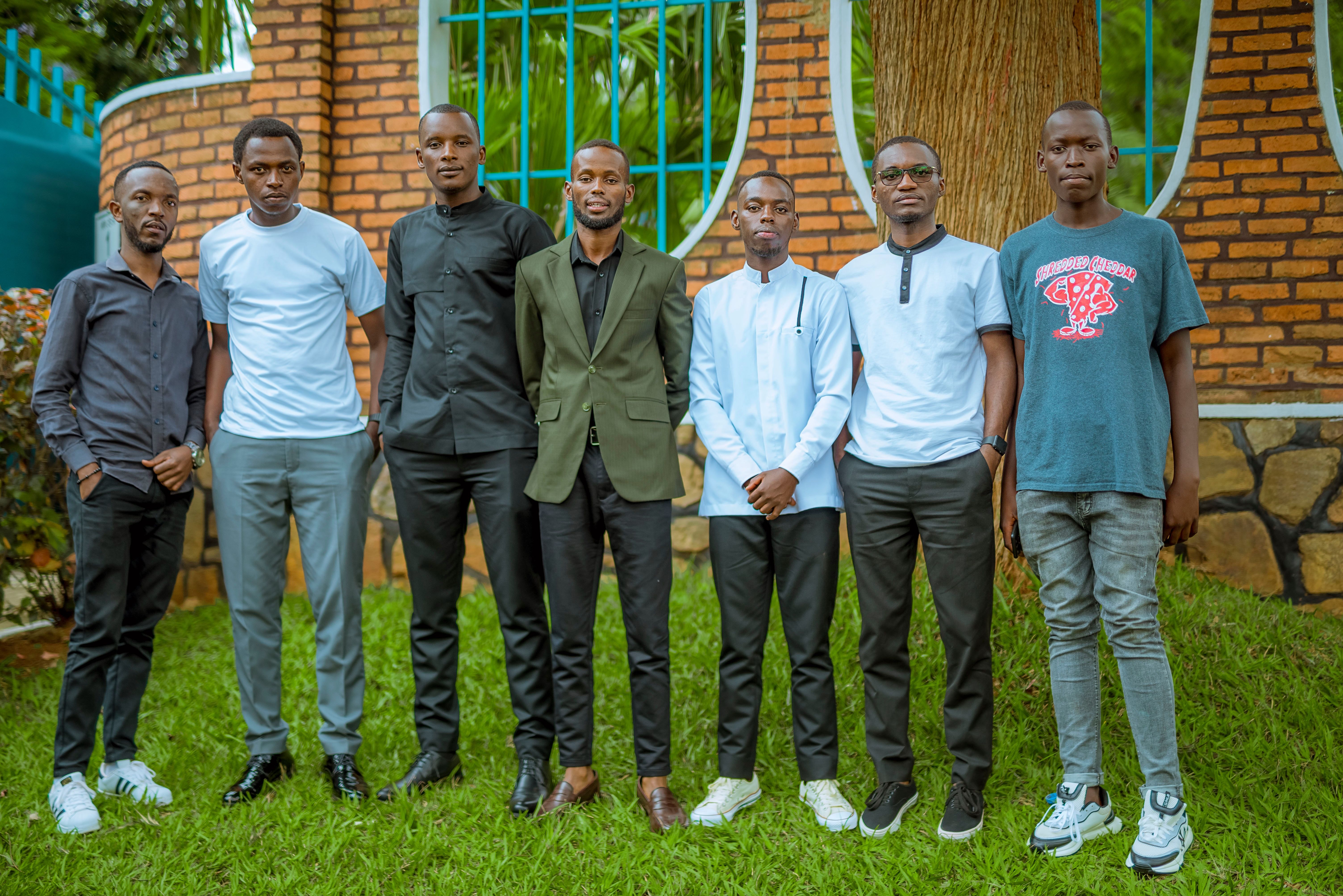 A group of young men standing in front of a brick building · Free Stock ...