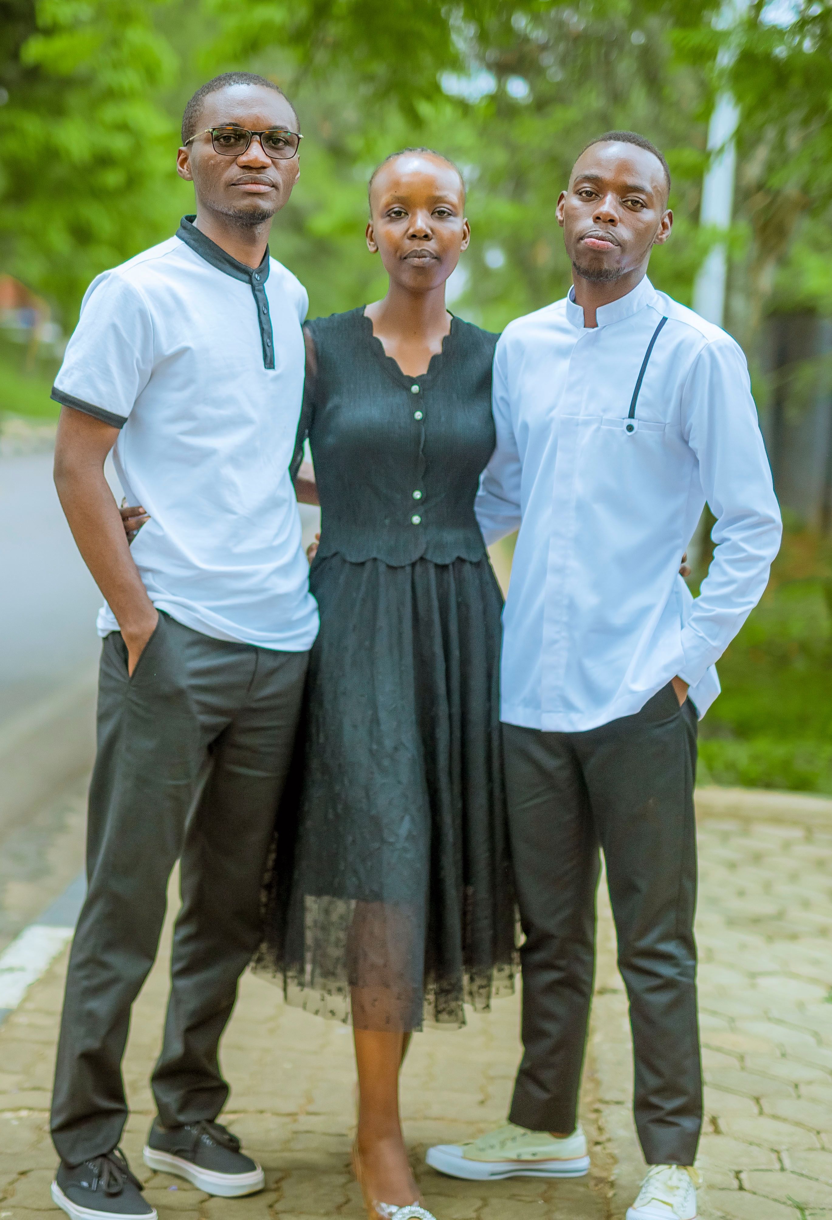 Three people standing together in a park · Free Stock Photo