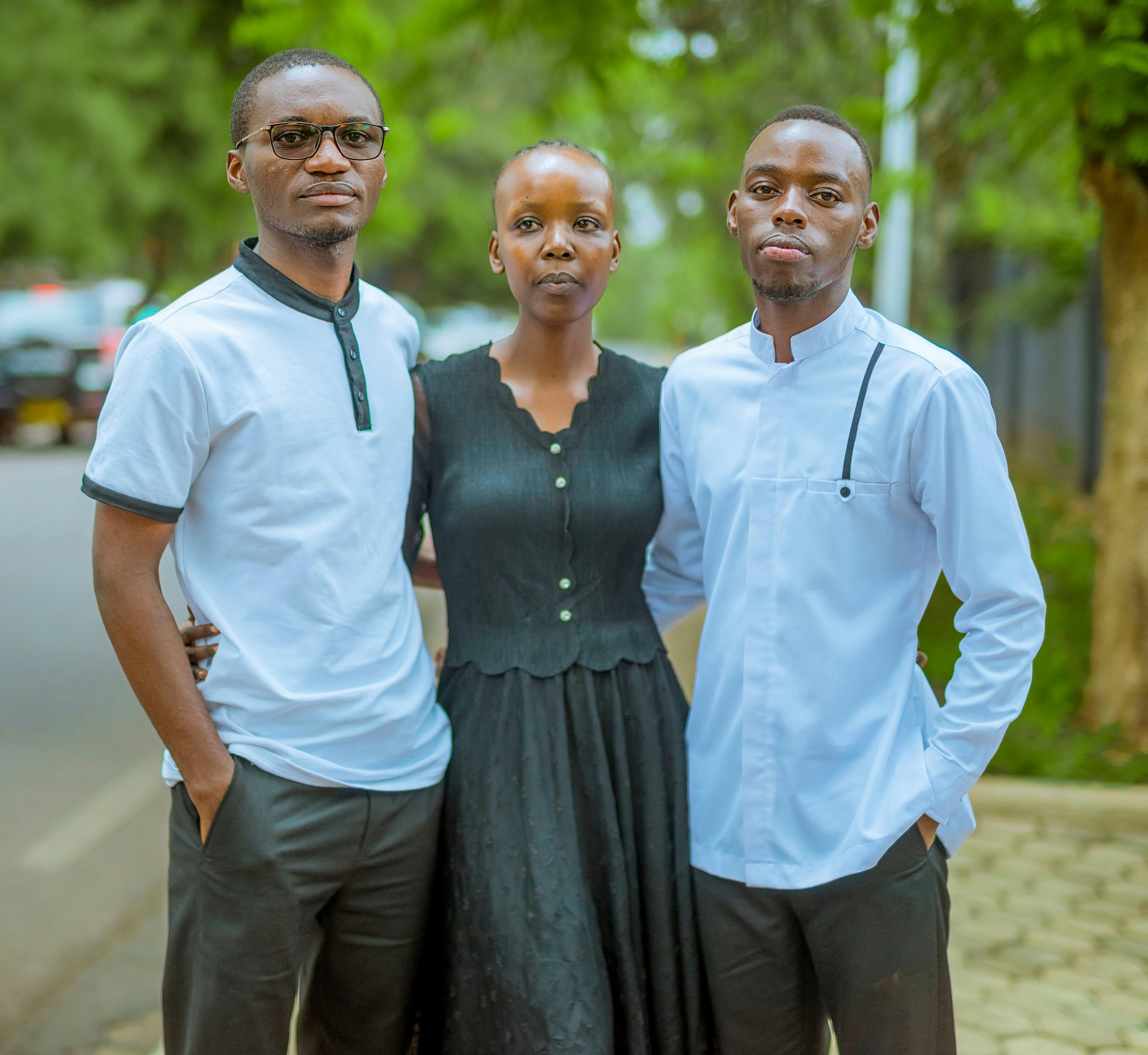 Three people standing together in a park · Free Stock Photo