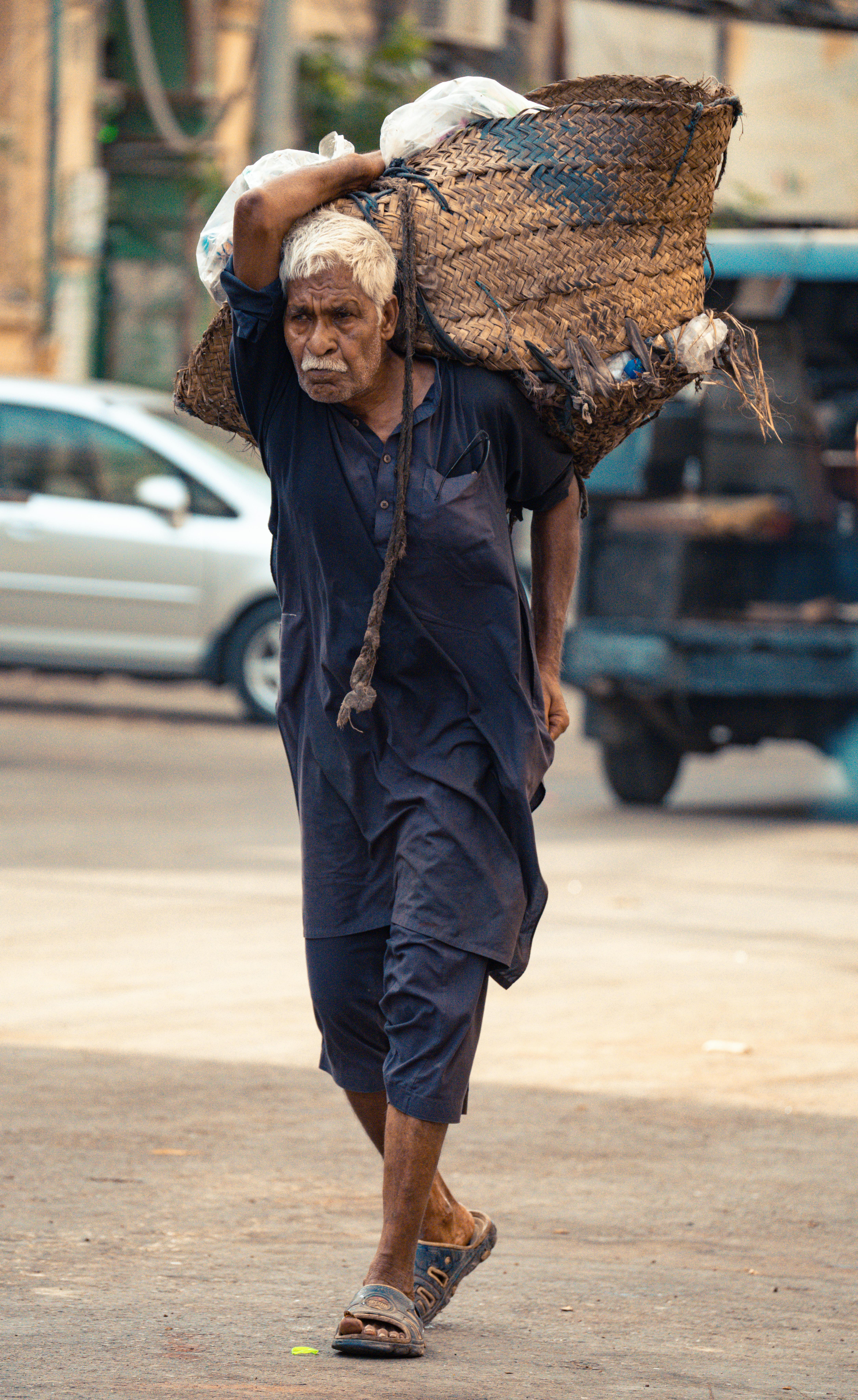 Elderly Man Carrying Heavy Load in Urban Street · Free Stock Photo