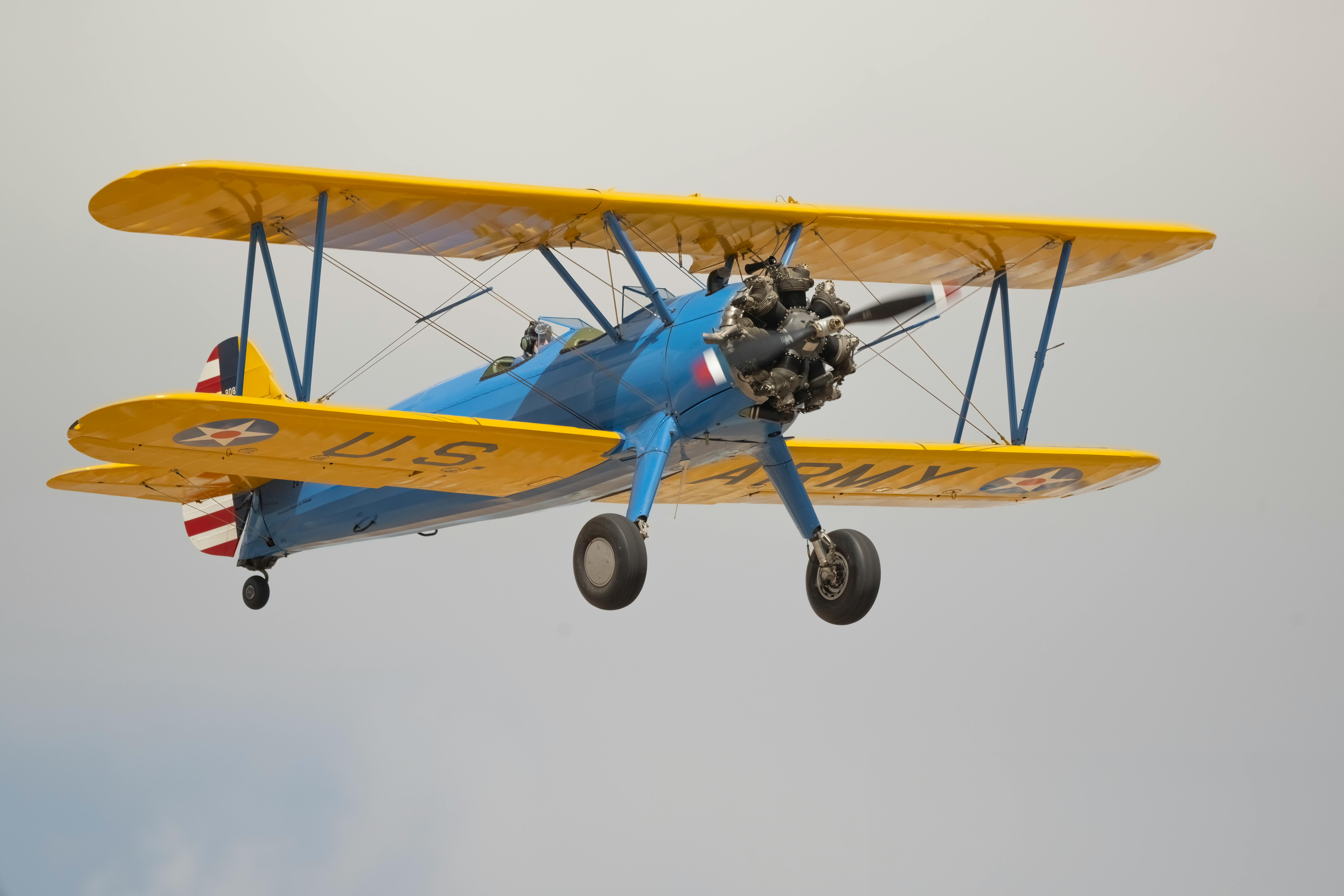 A yellow biplane flying in the sky · Free Stock Photo