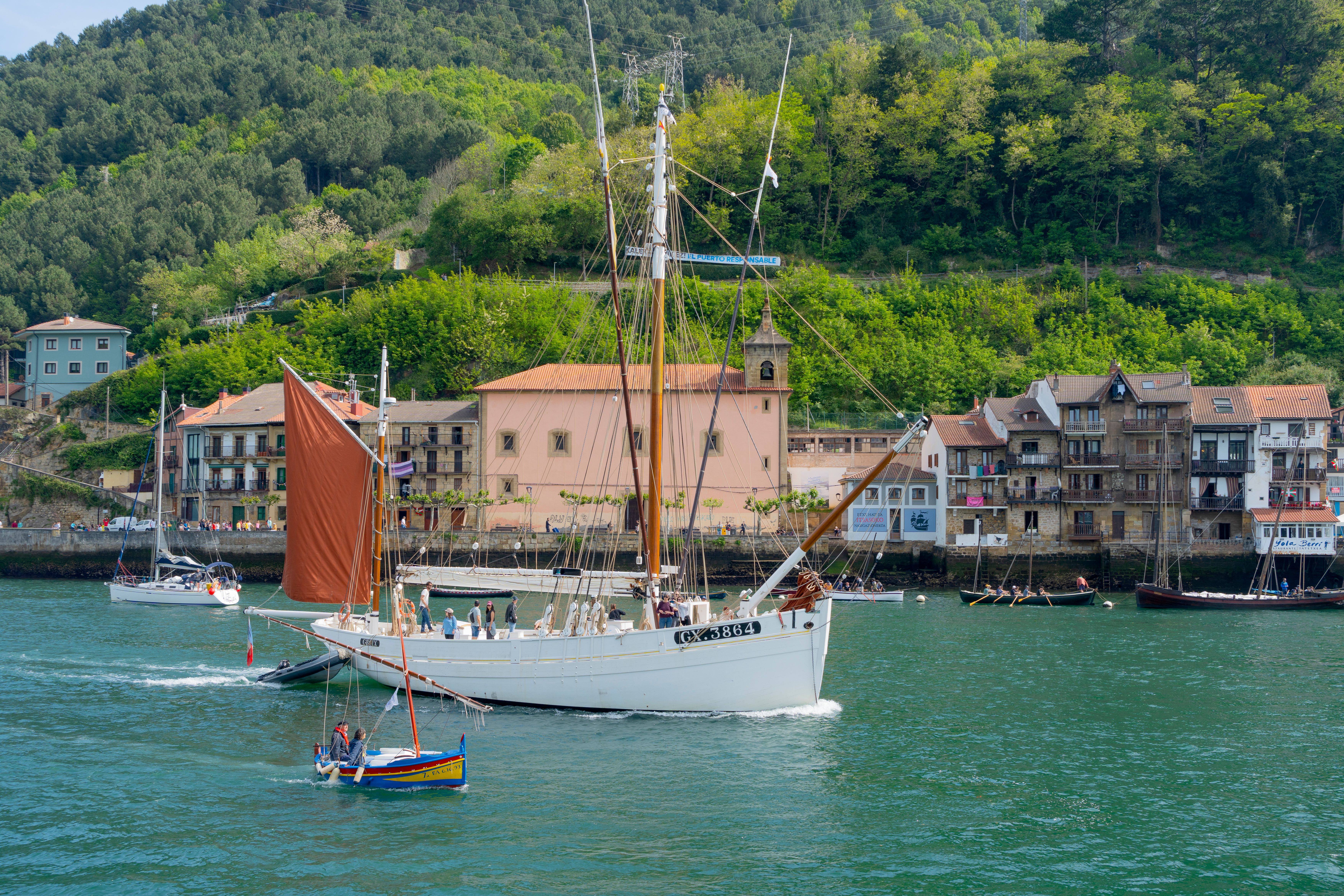 A boat is sailing down the water with a sail · Free Stock Photo