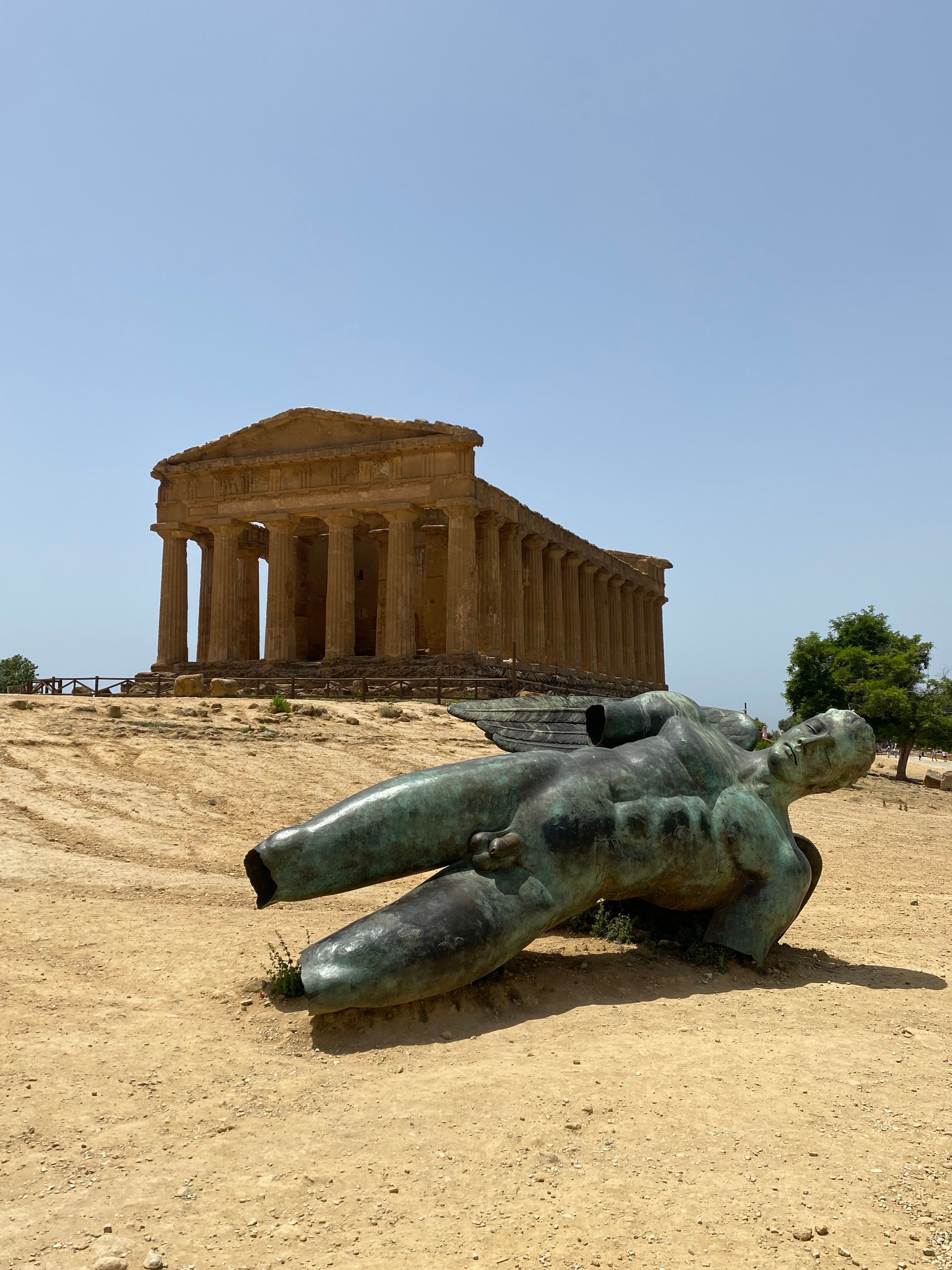 A statue of a man lying on the ground in front of a building · Free ...