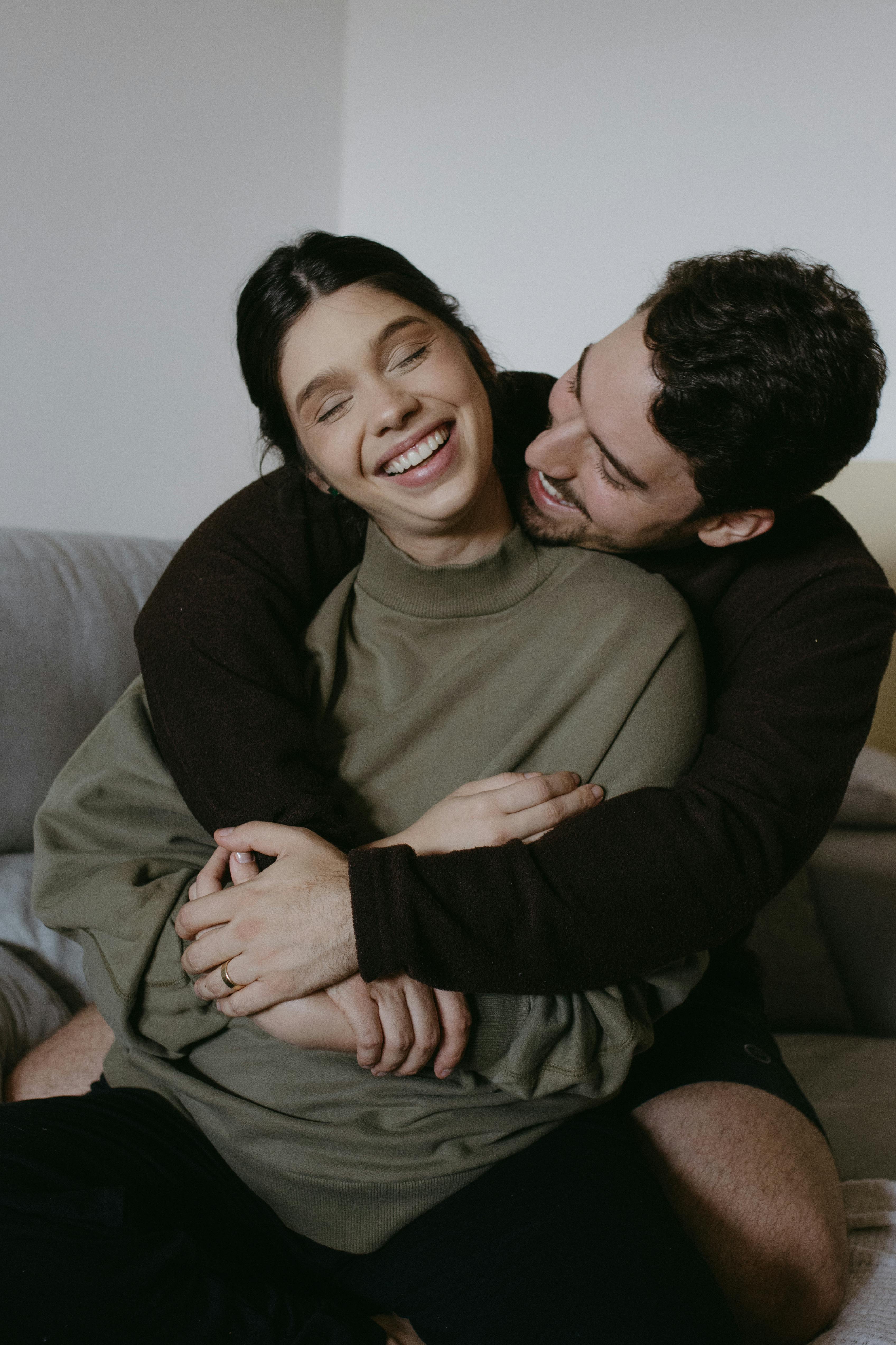 Couple hugging on couch in living room · Free Stock Photo
