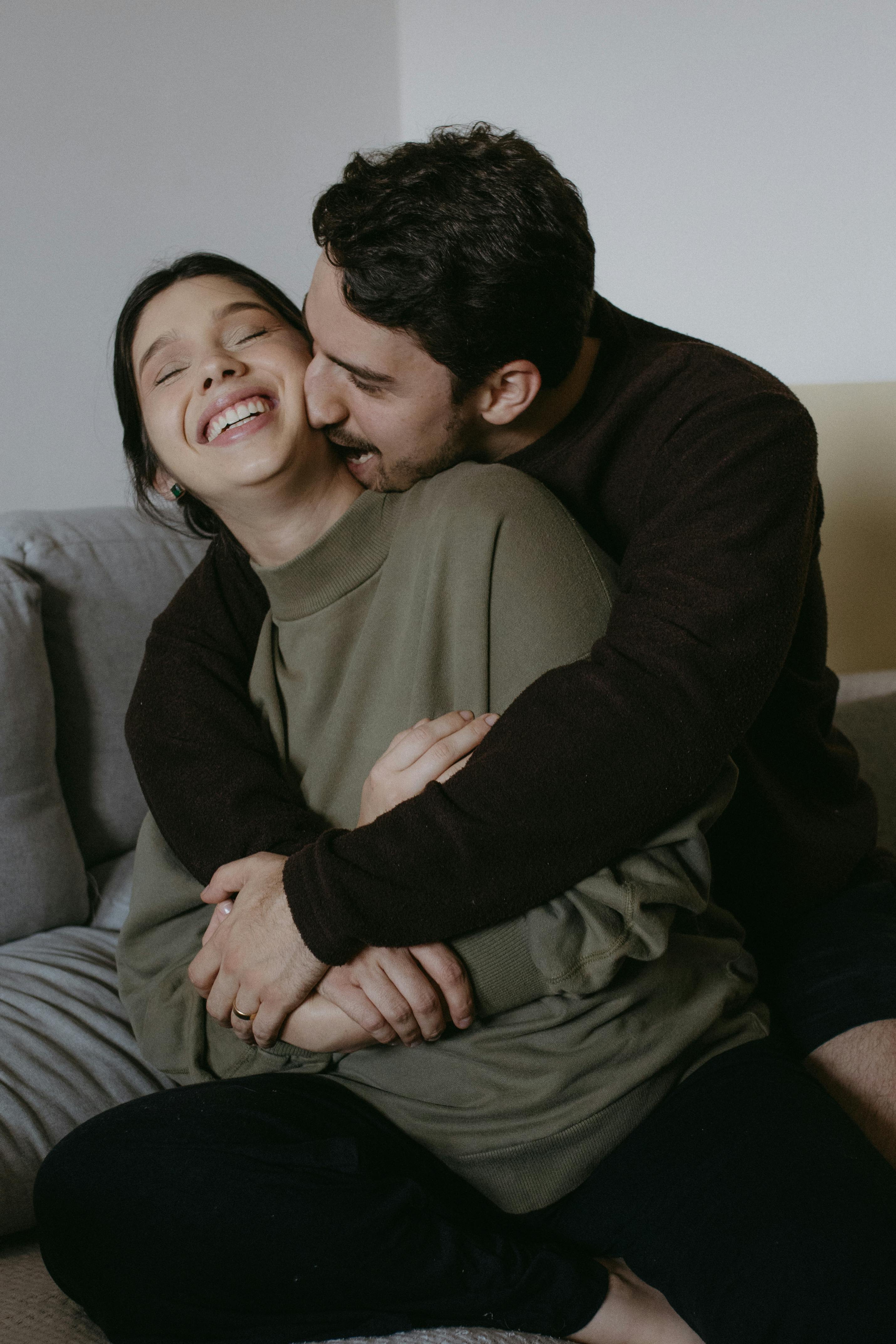 Couple hugging on couch in living room · Free Stock Photo