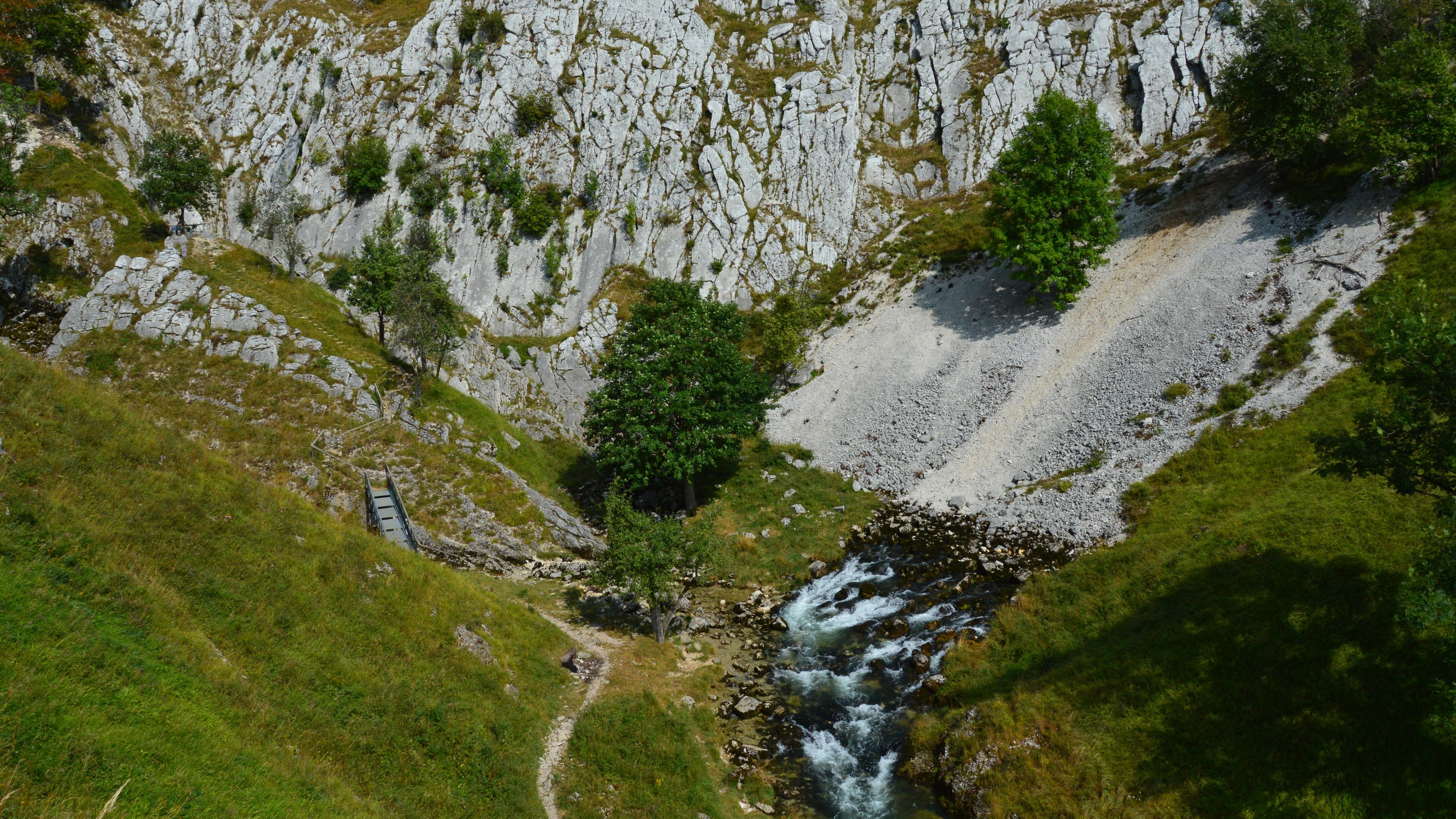 A small stream runs through a rocky valley · Free Stock Photo