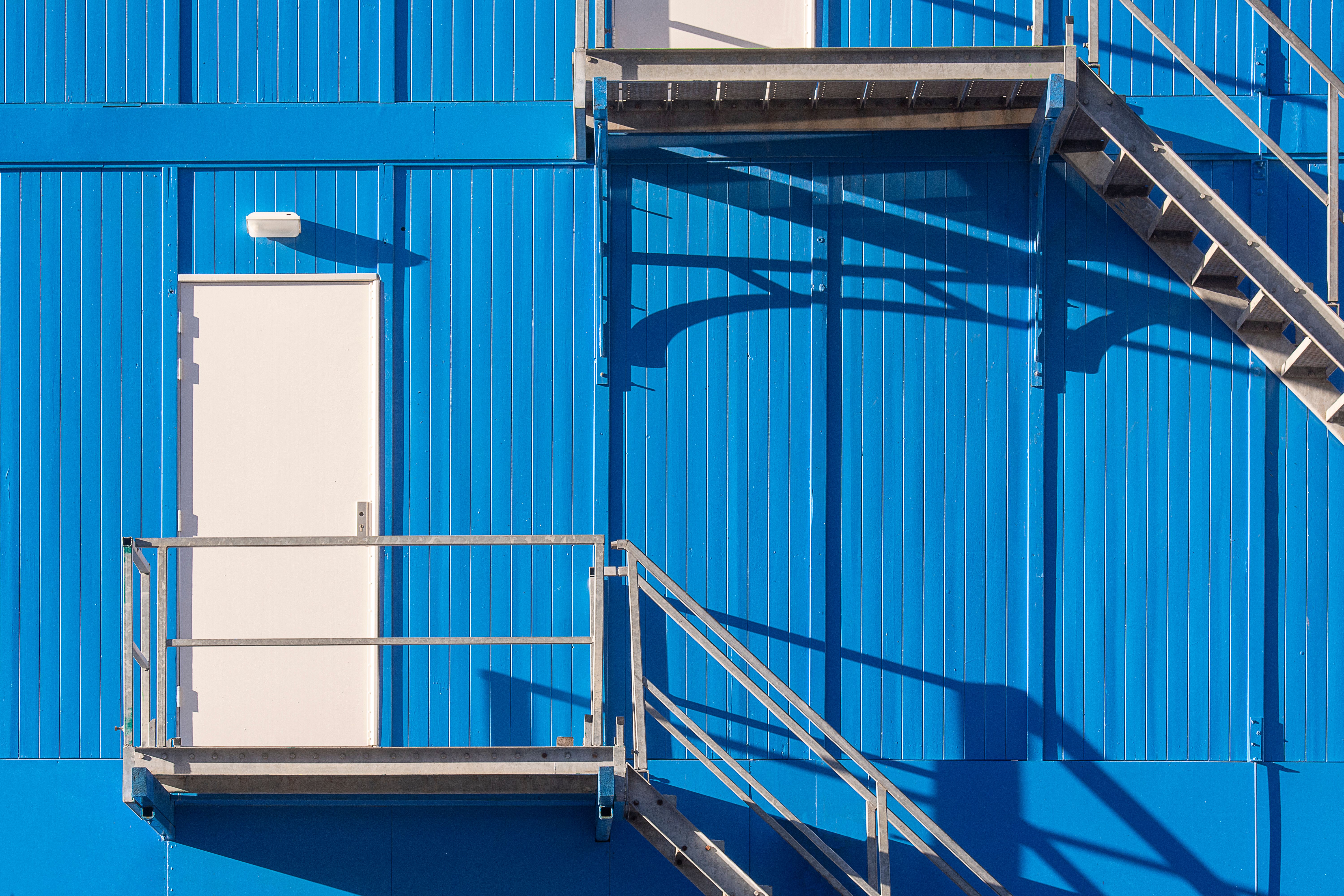 A blue building with stairs and metal steps · Free Stock Photo