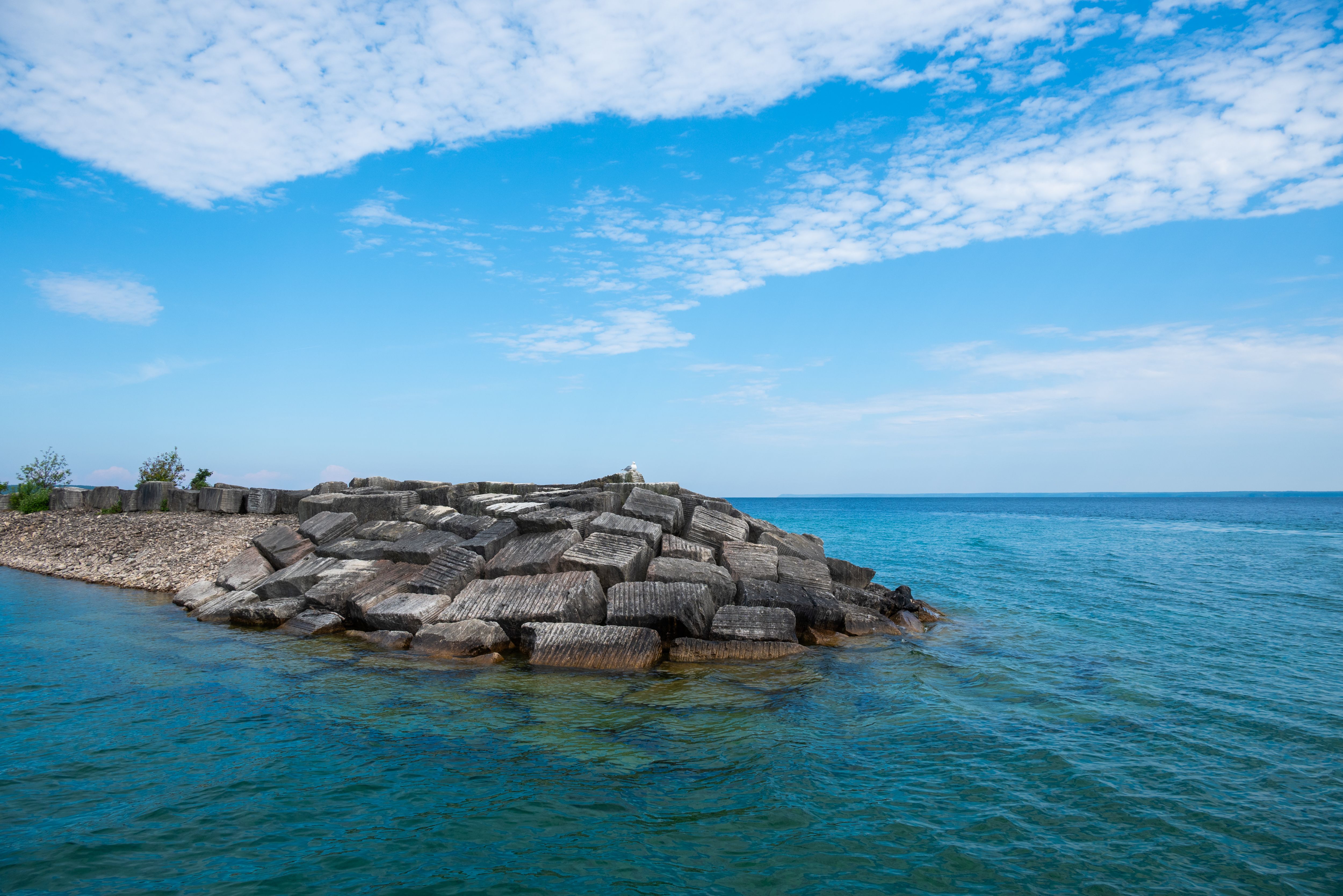 A large rock in the water near the shore · Free Stock Photo