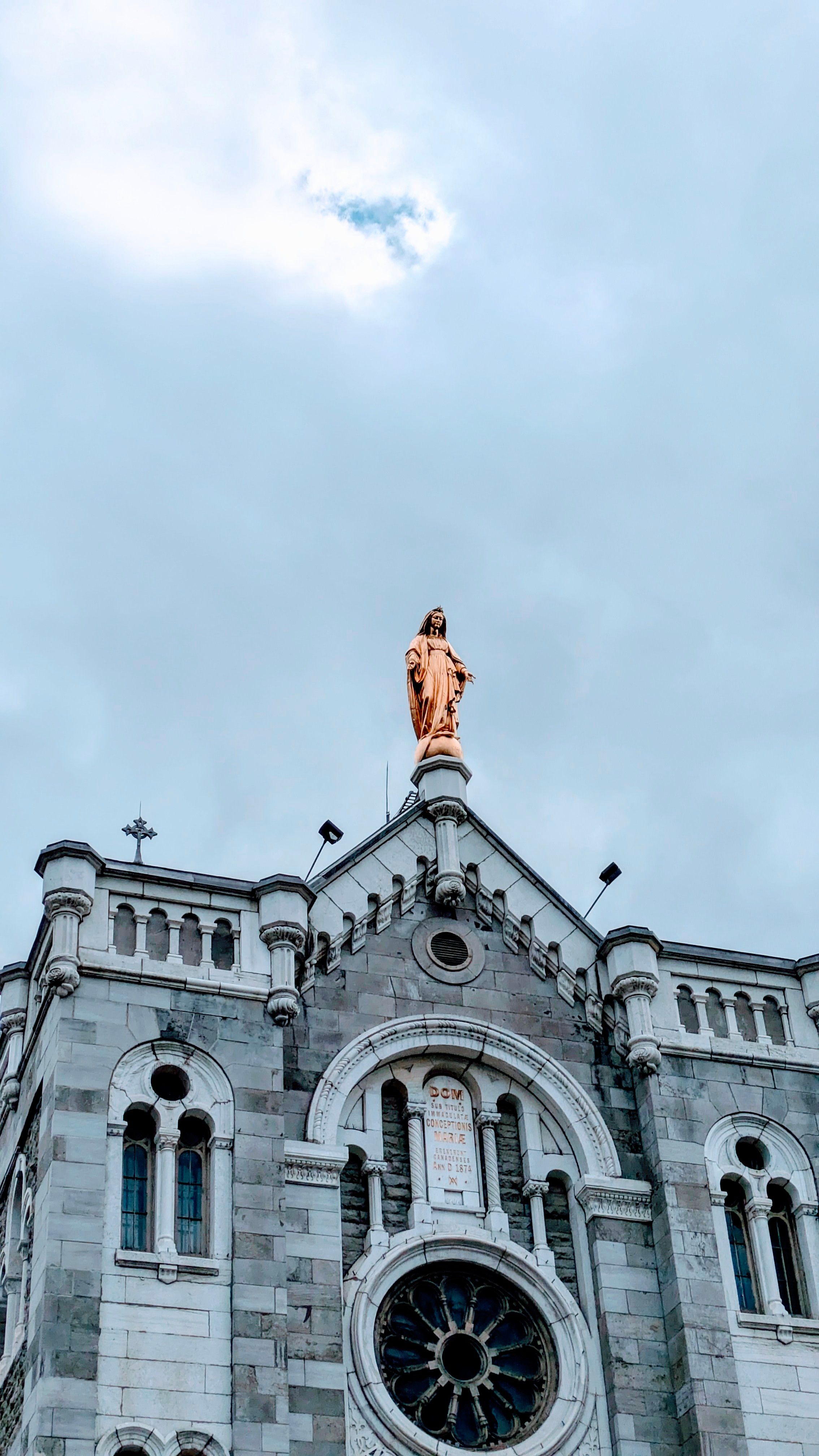 A statue of the virgin Mary on top of a church · Free Stock Photo