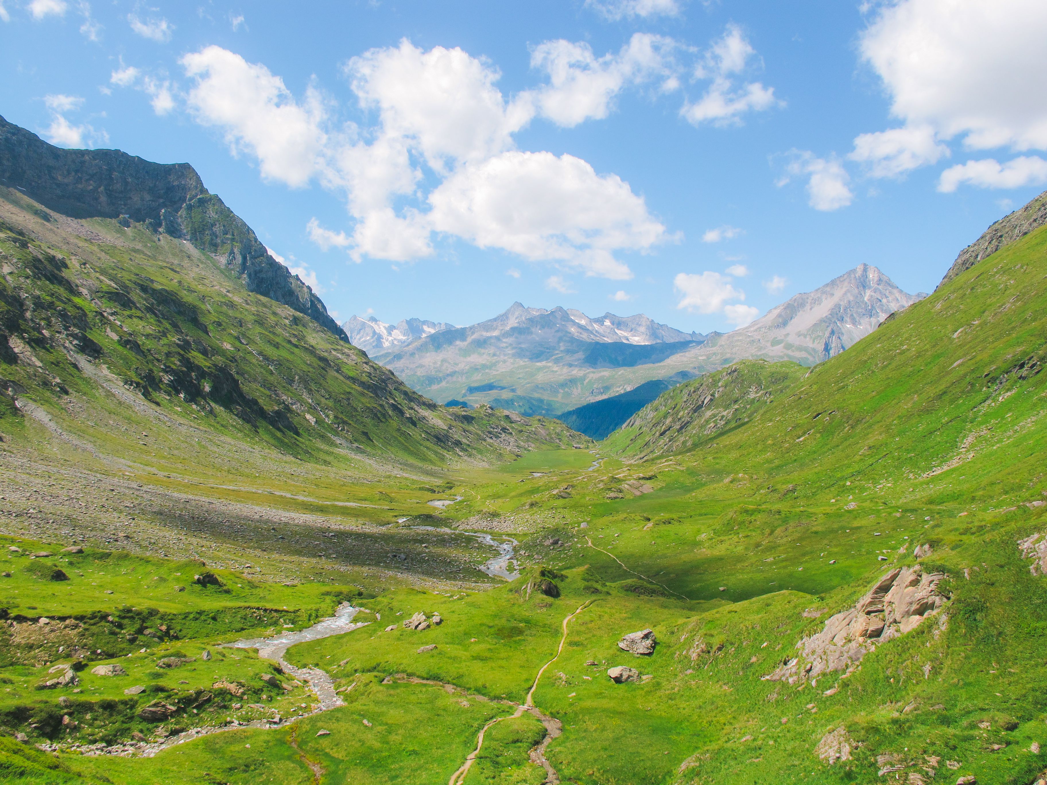 A valley with green grass and mountains in the background · Free Stock ...