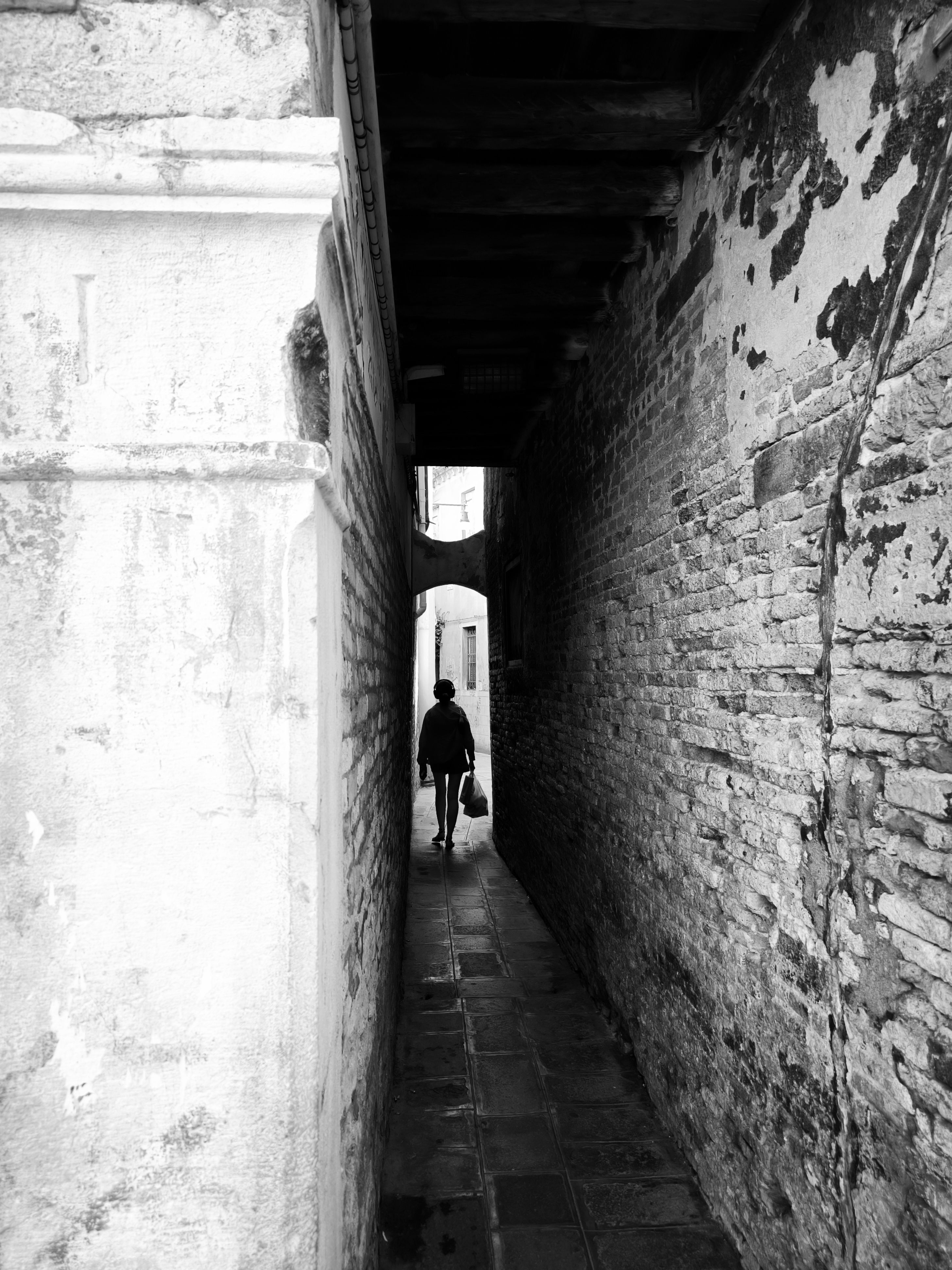 A person walking down a narrow alleyway · Free Stock Photo