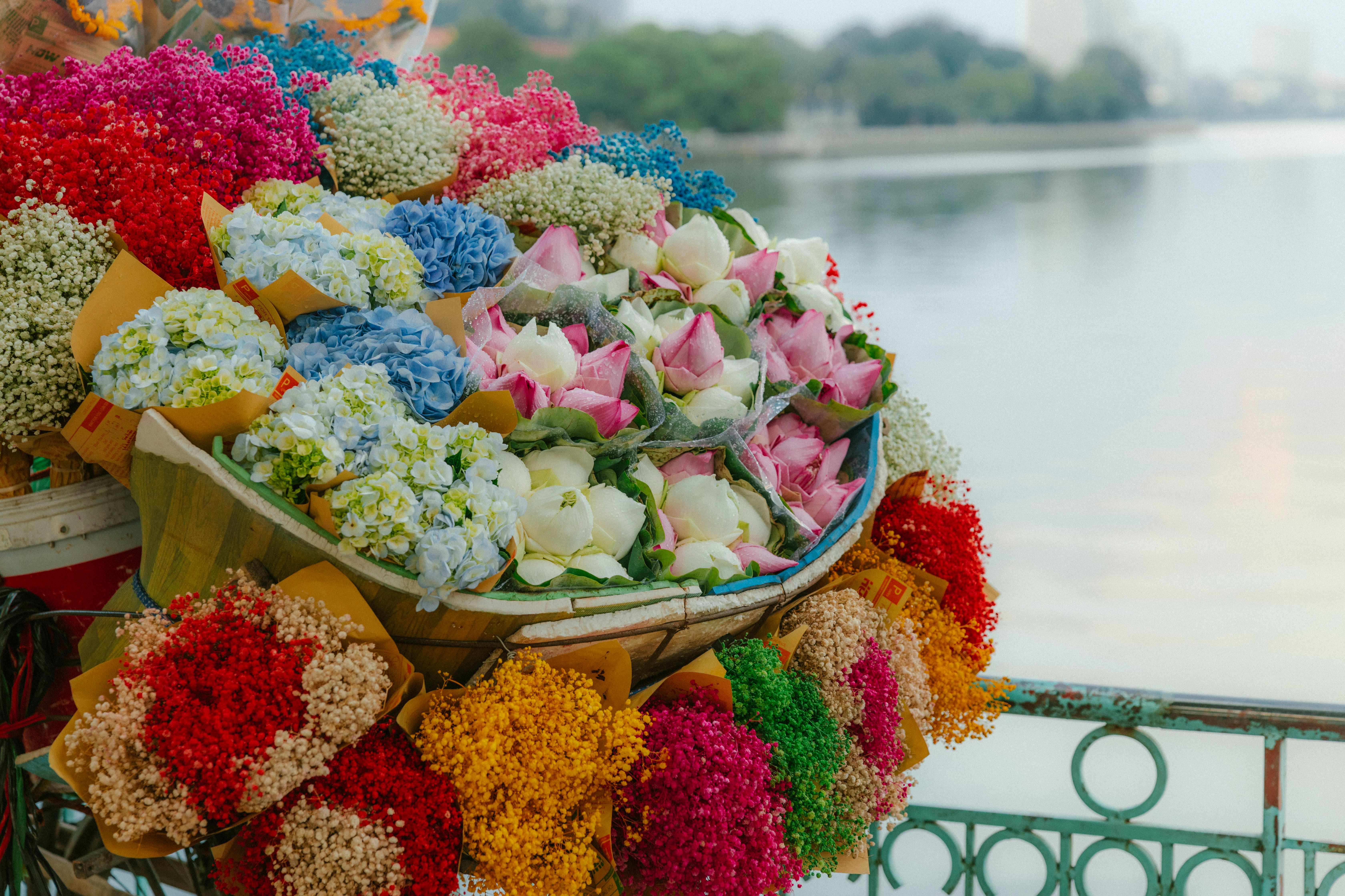 Vibrant Flower Bouquets on Riverside Display · Free Stock Photo