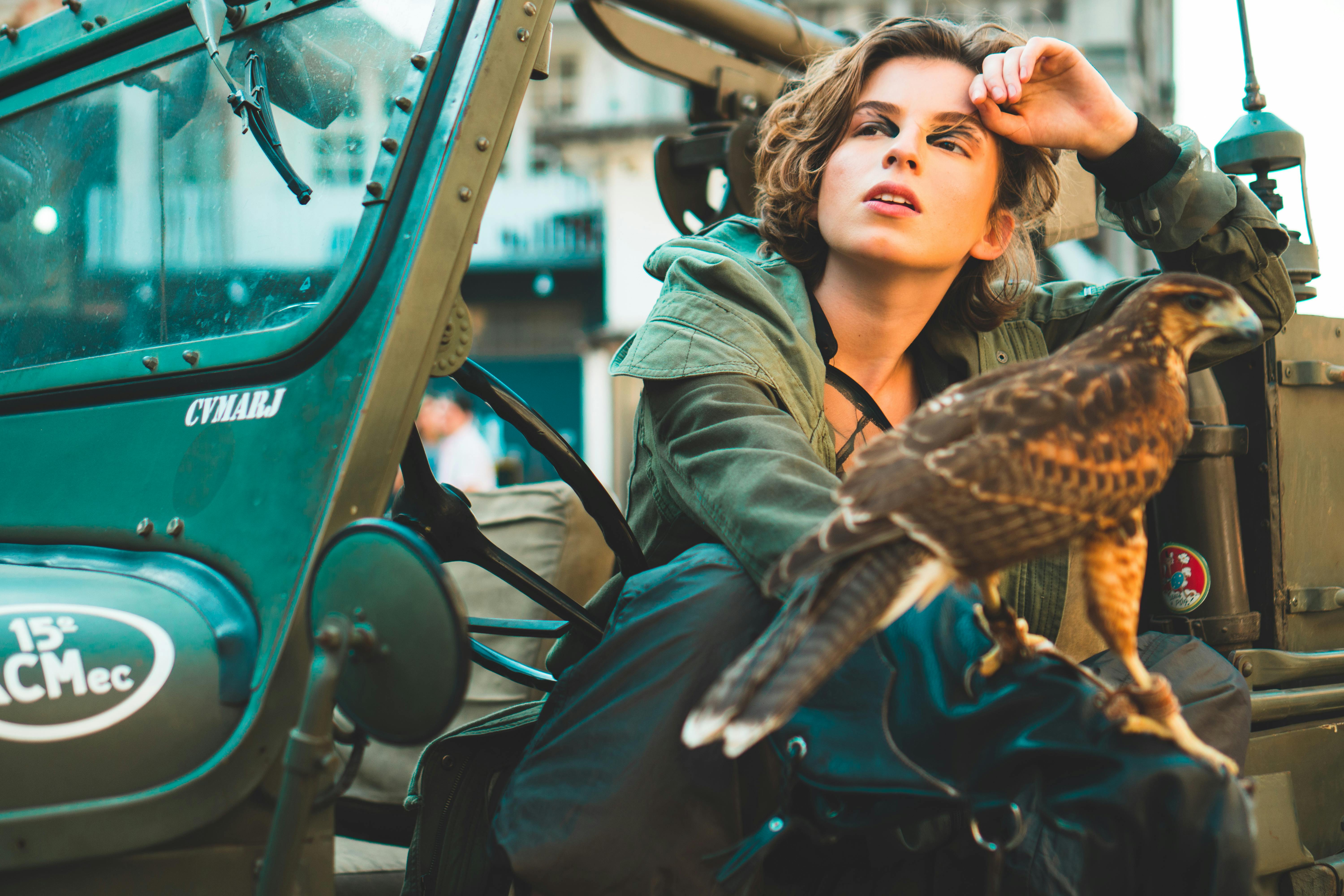 Man Holding a Stick with Perched Bird · Free Stock Photo