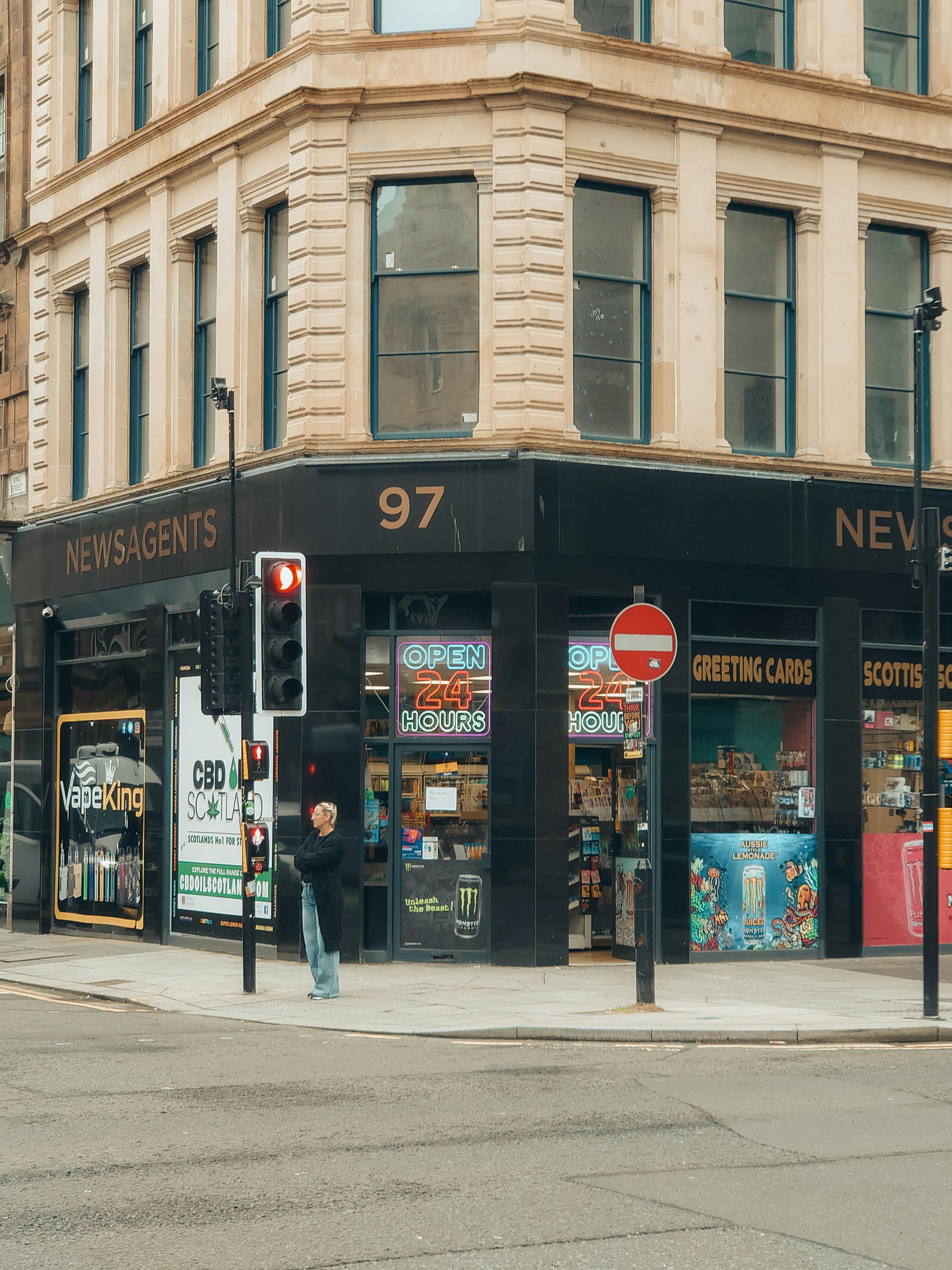 A man is walking down the street in front of a store · Free Stock Photo