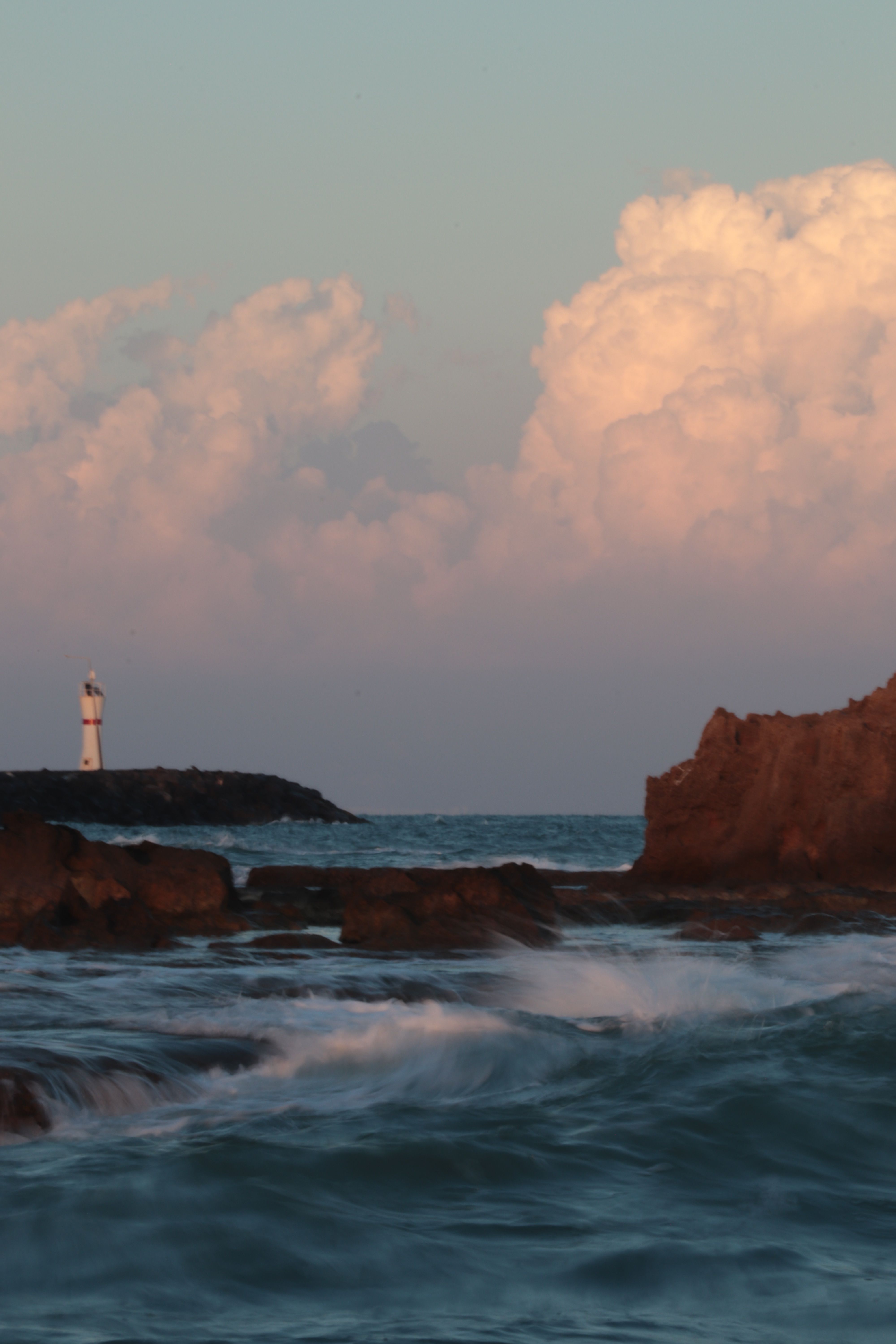 A lighthouse is seen in the distance with the ocean in the background ...