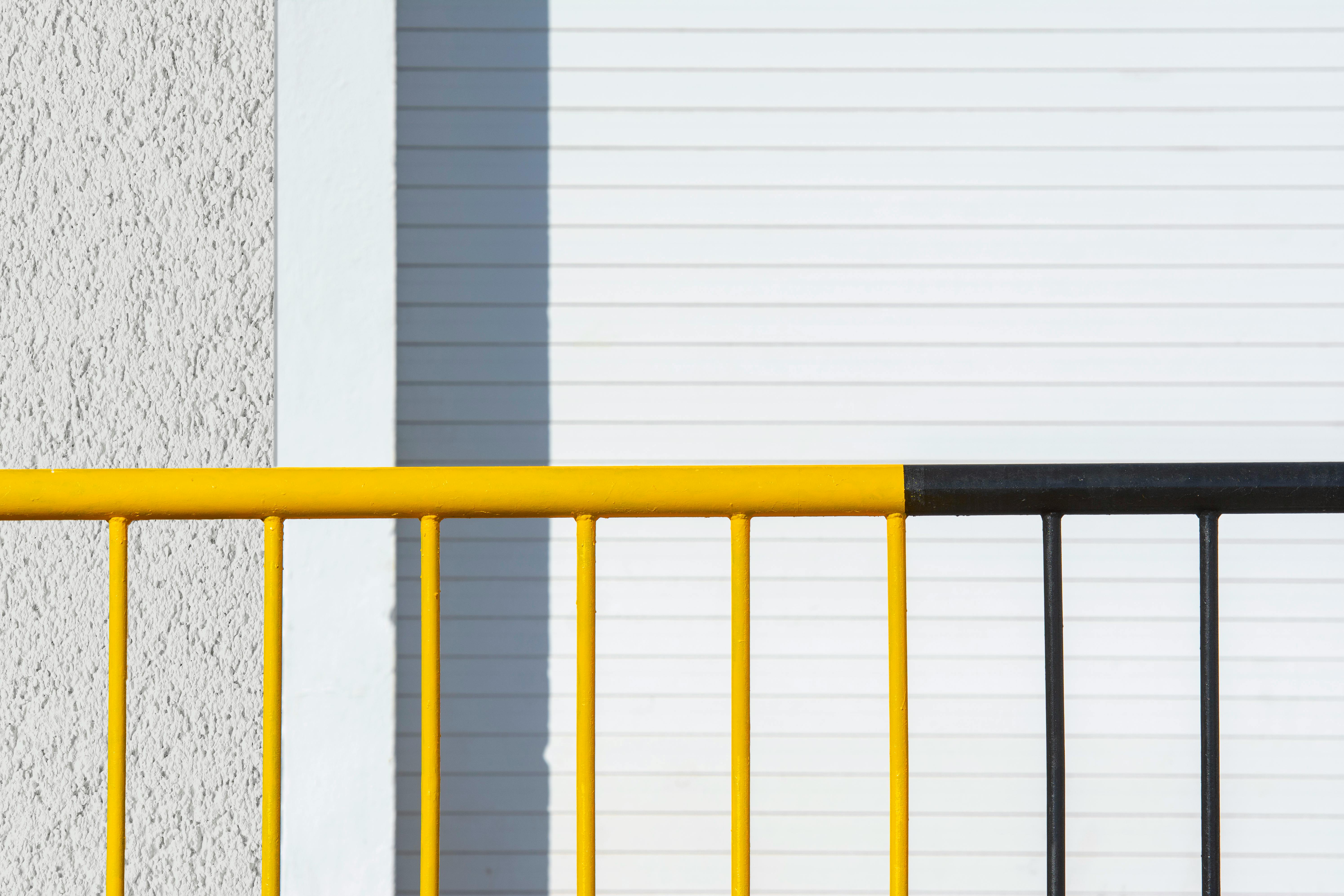 A yellow and black railing with a white door · Free Stock Photo
