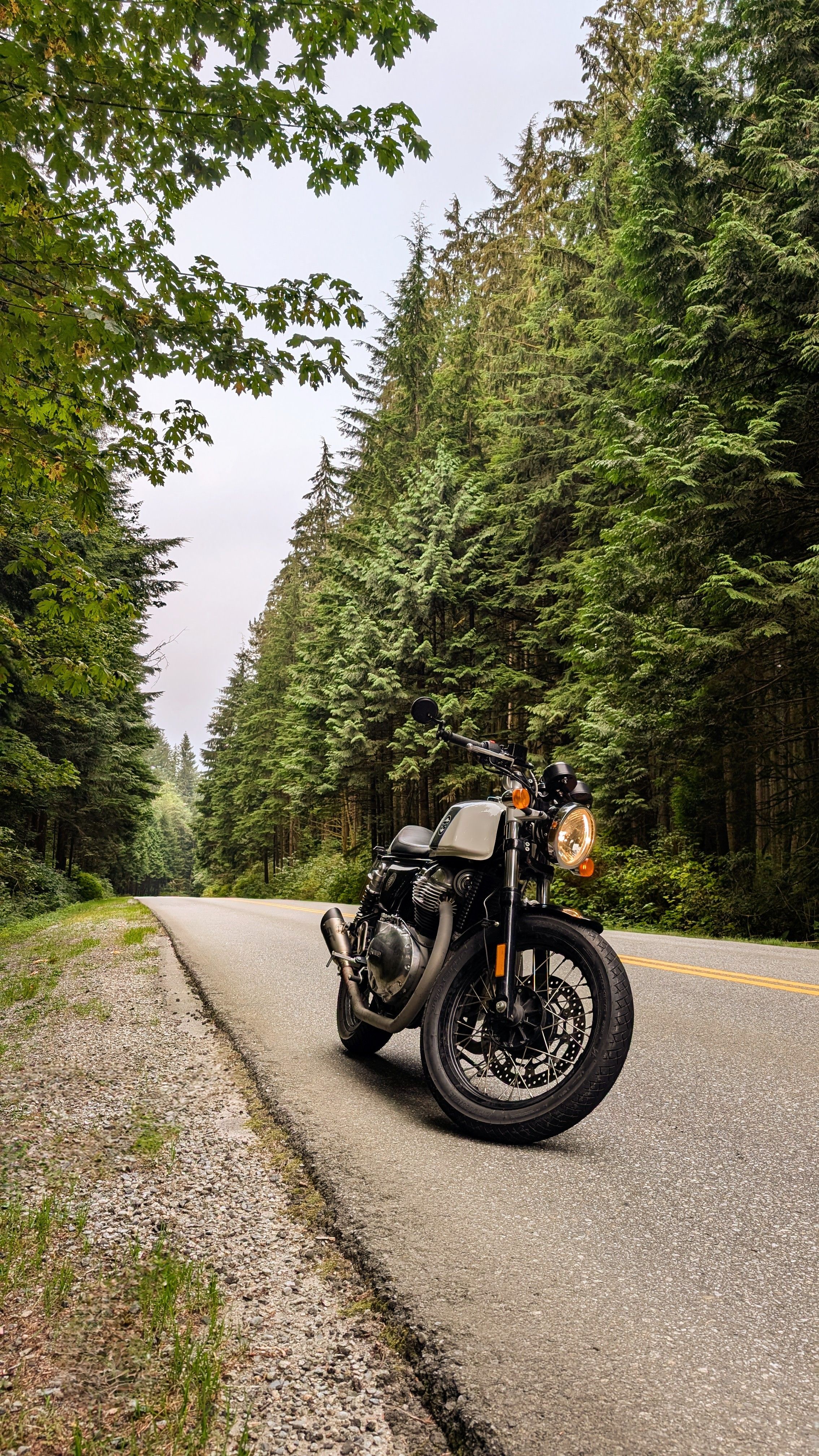 A motorcycle is parked on the side of the road · Free Stock Photo