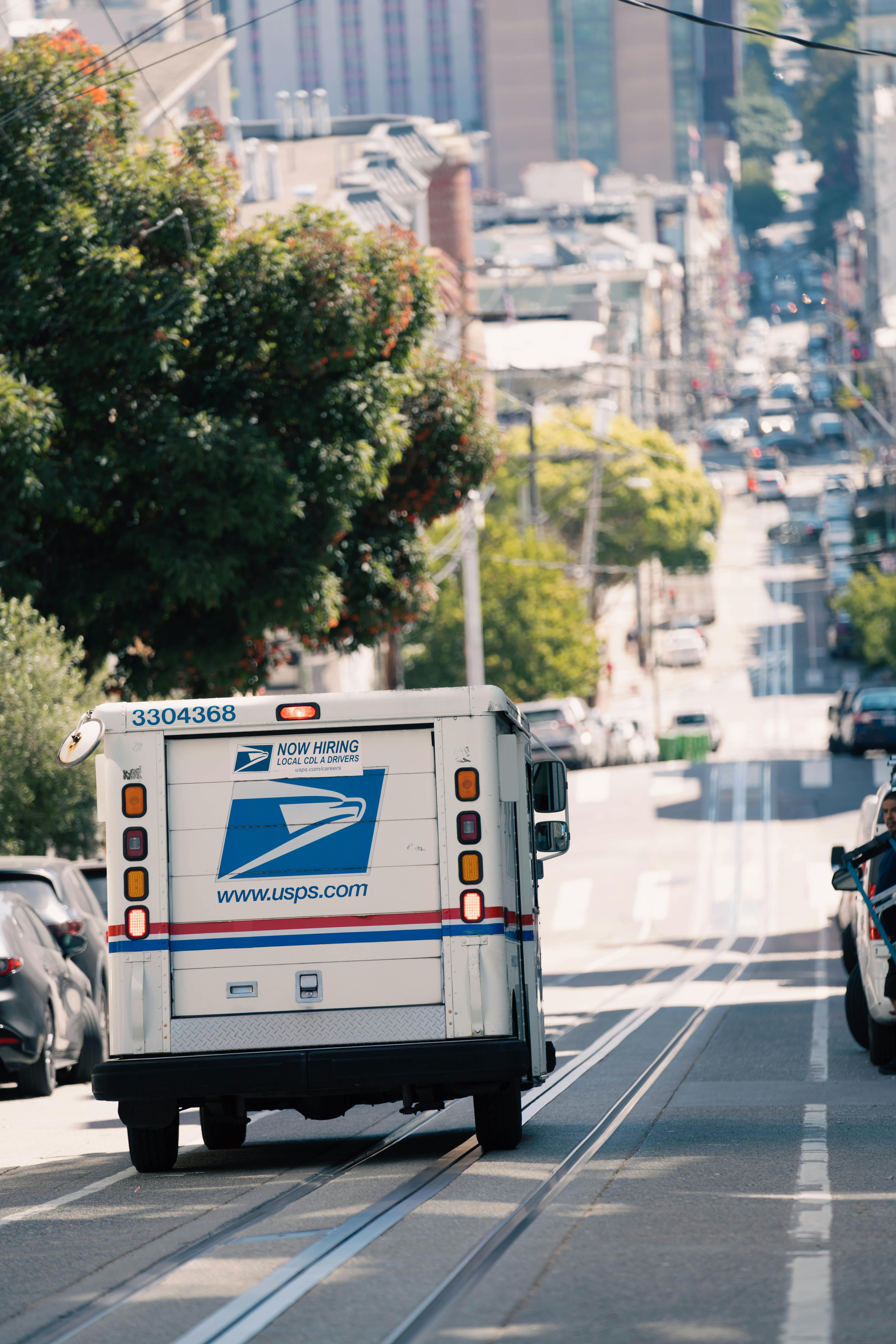 USPS Truck on a Busy Urban Street · Free Stock Photo