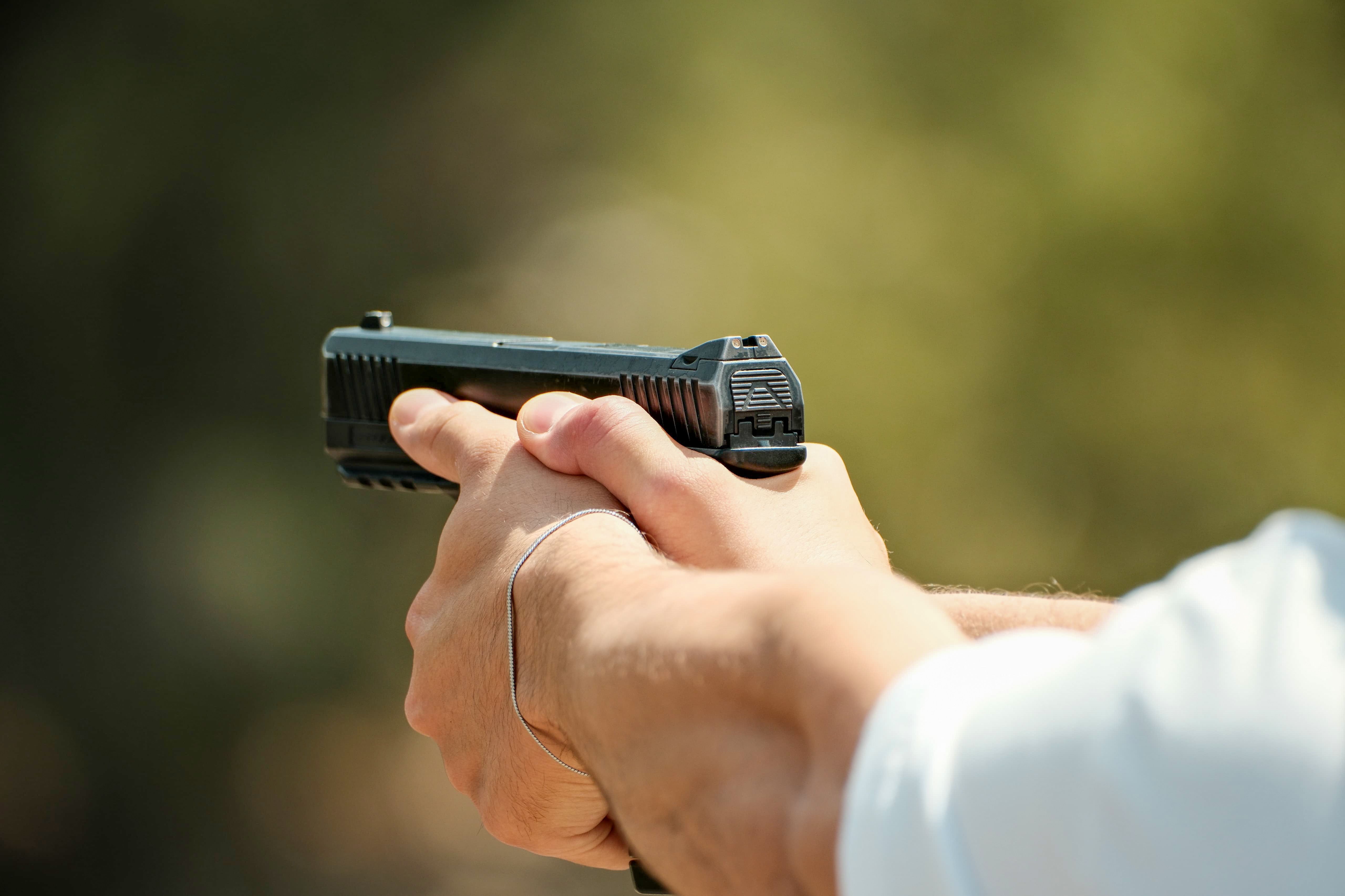 A Person Holding a Pistol · Free Stock Photo