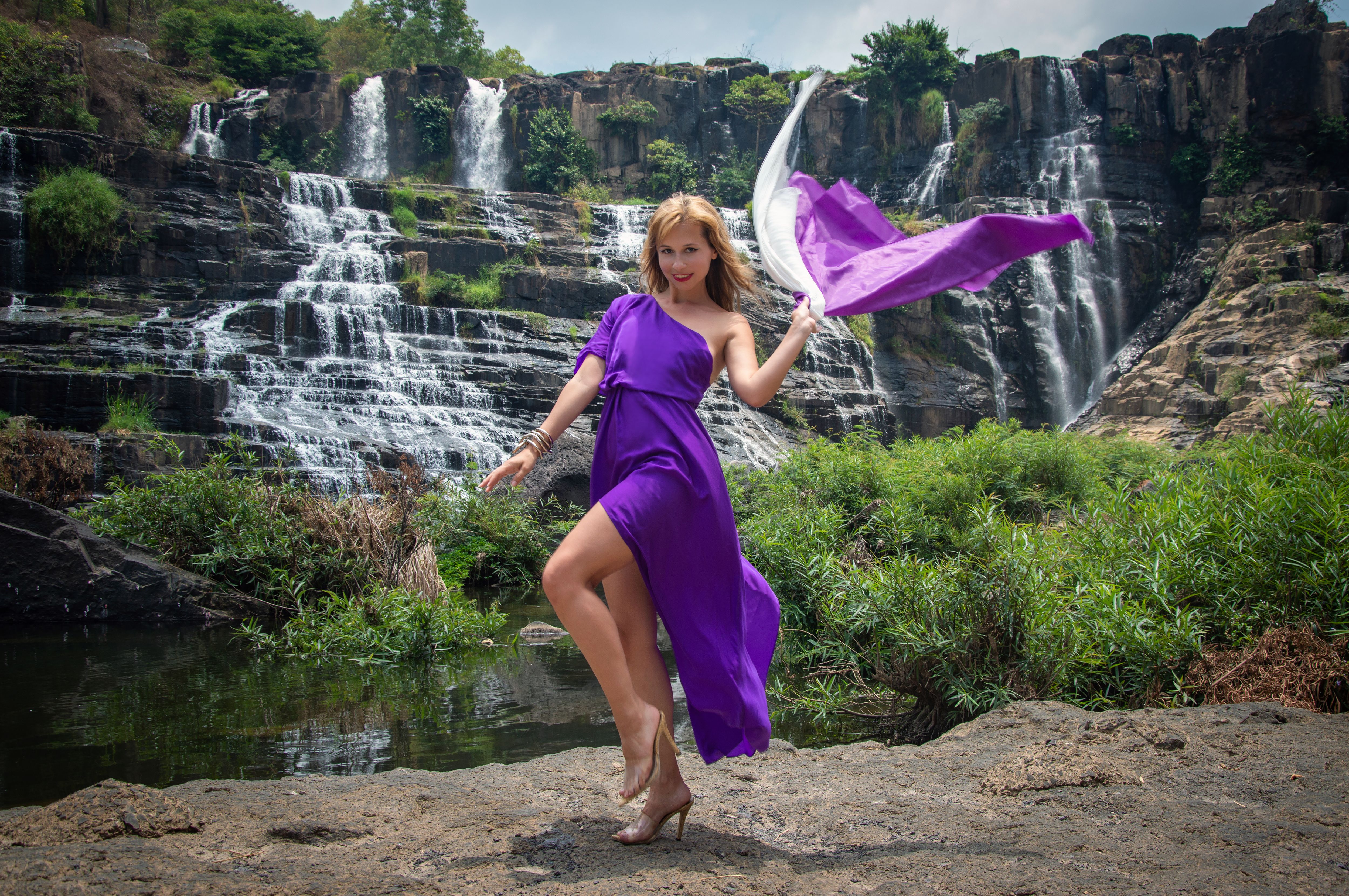 Woman in Dress Posing near Waterfalls on Rocks · Free Stock Photo