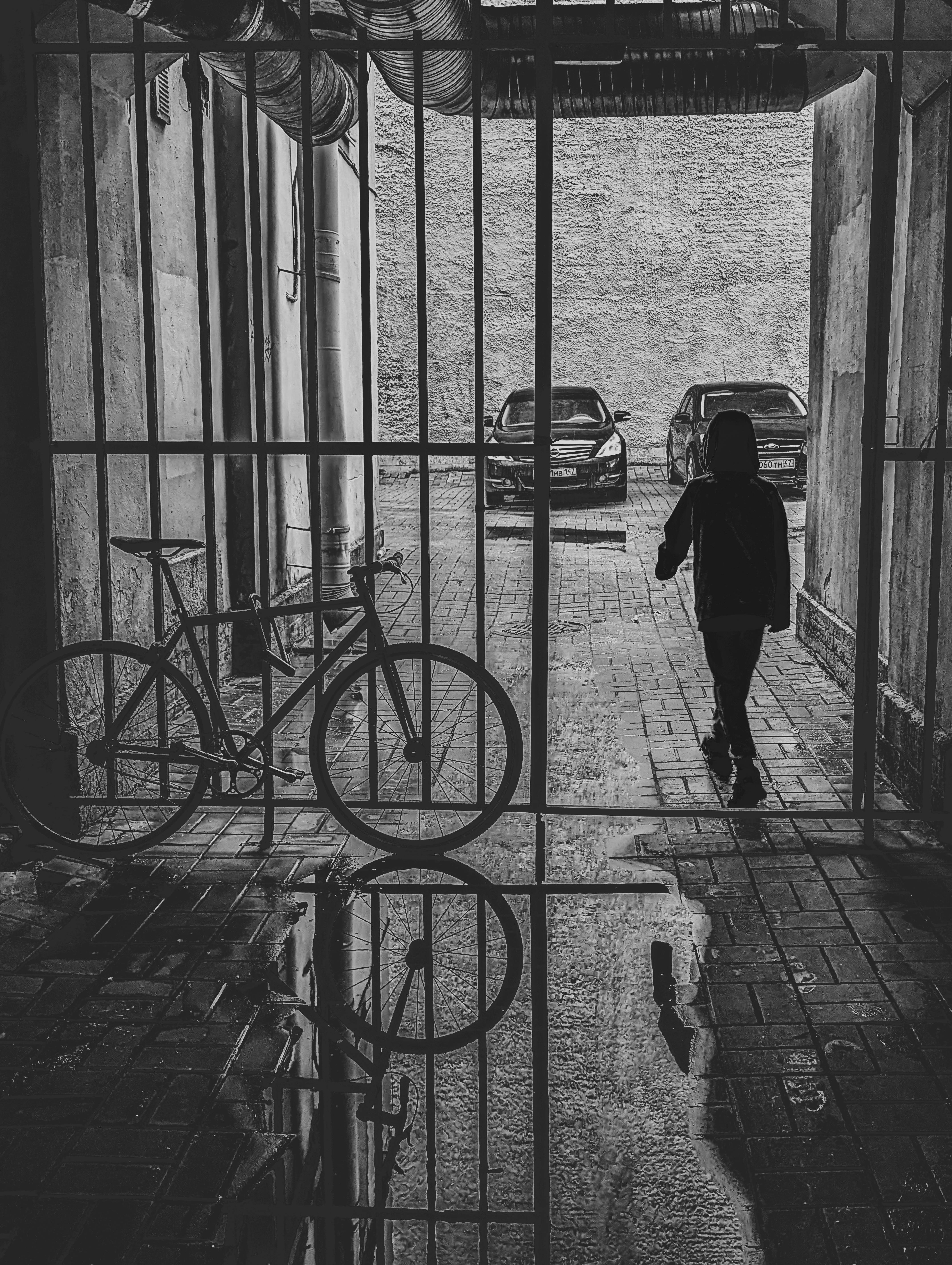 Person Walking through Gate near Bicycle · Free Stock Photo
