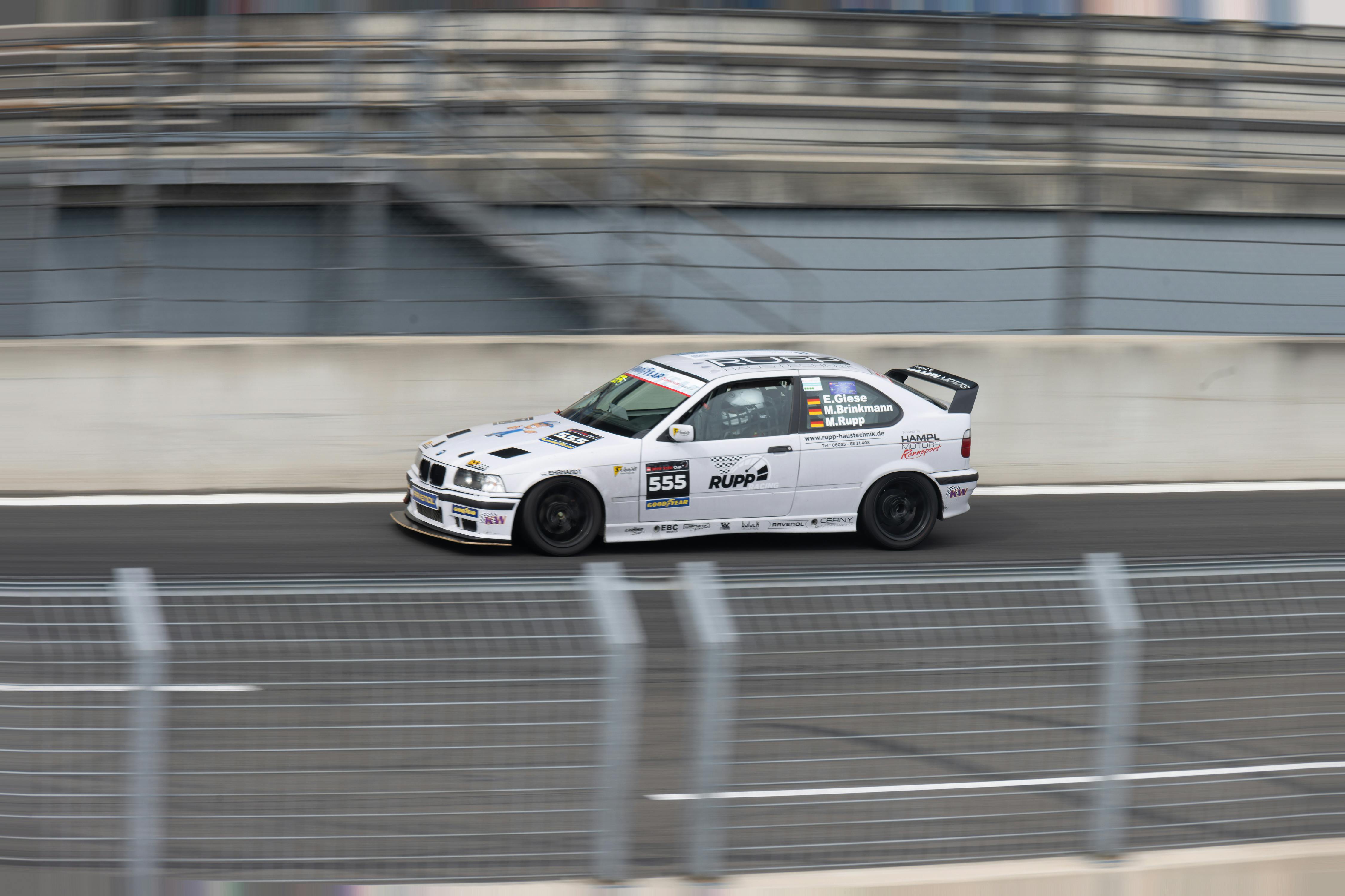 High-speed racing car on track in motion · Free Stock Photo