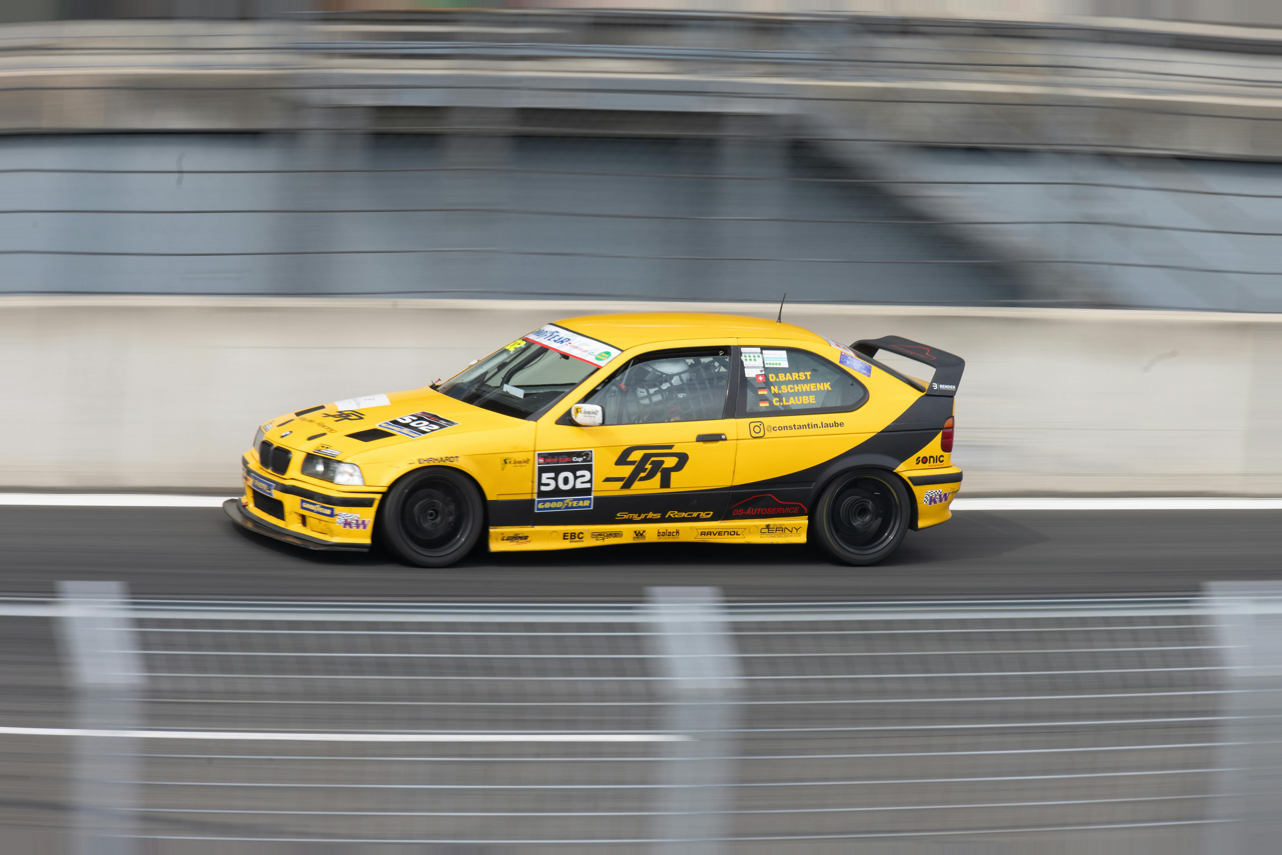 Yellow Racing Car on Urban Track in Motion · Free Stock Photo